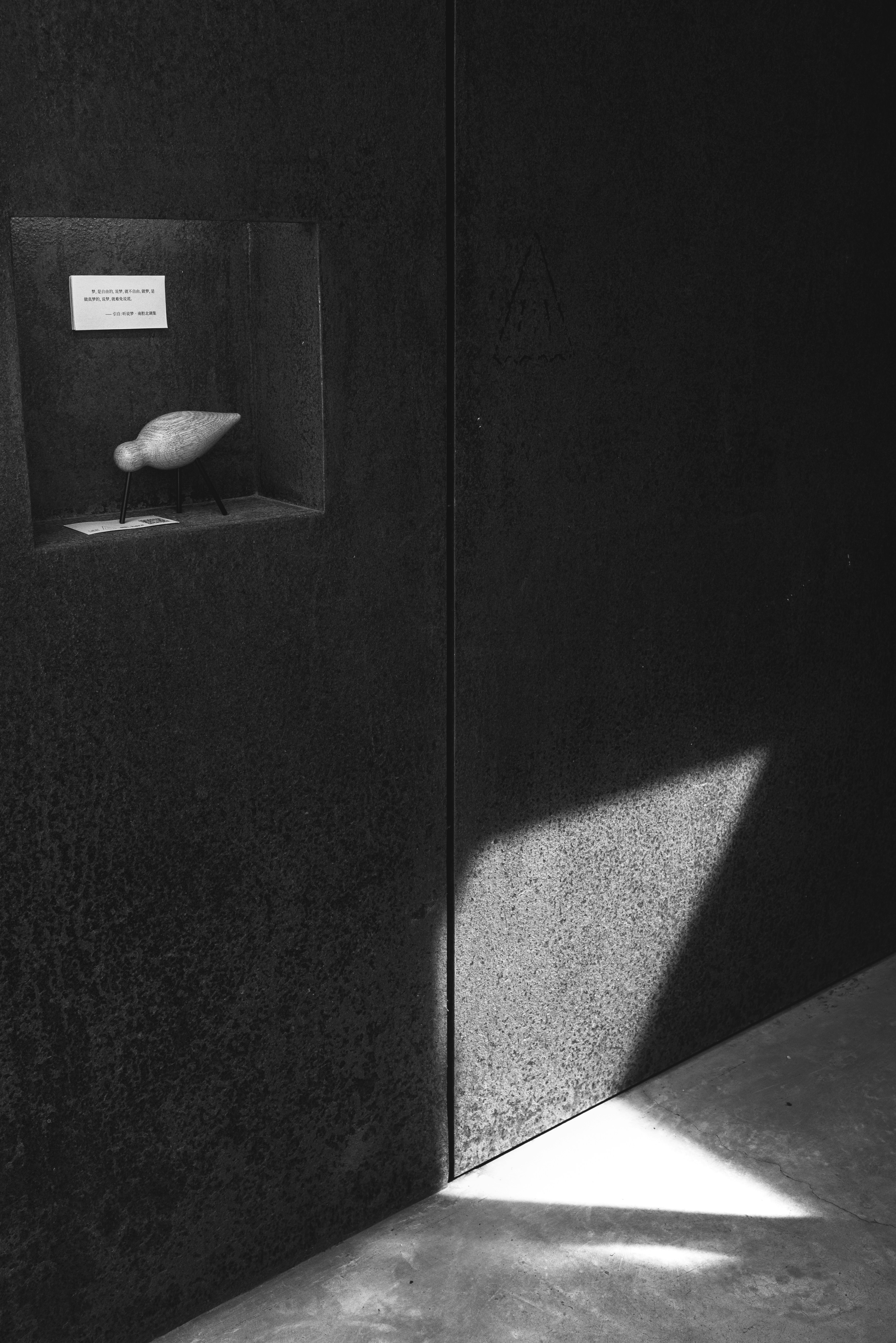 Shadowed Geometry and a Glass Vessel in a Monochrome Niche