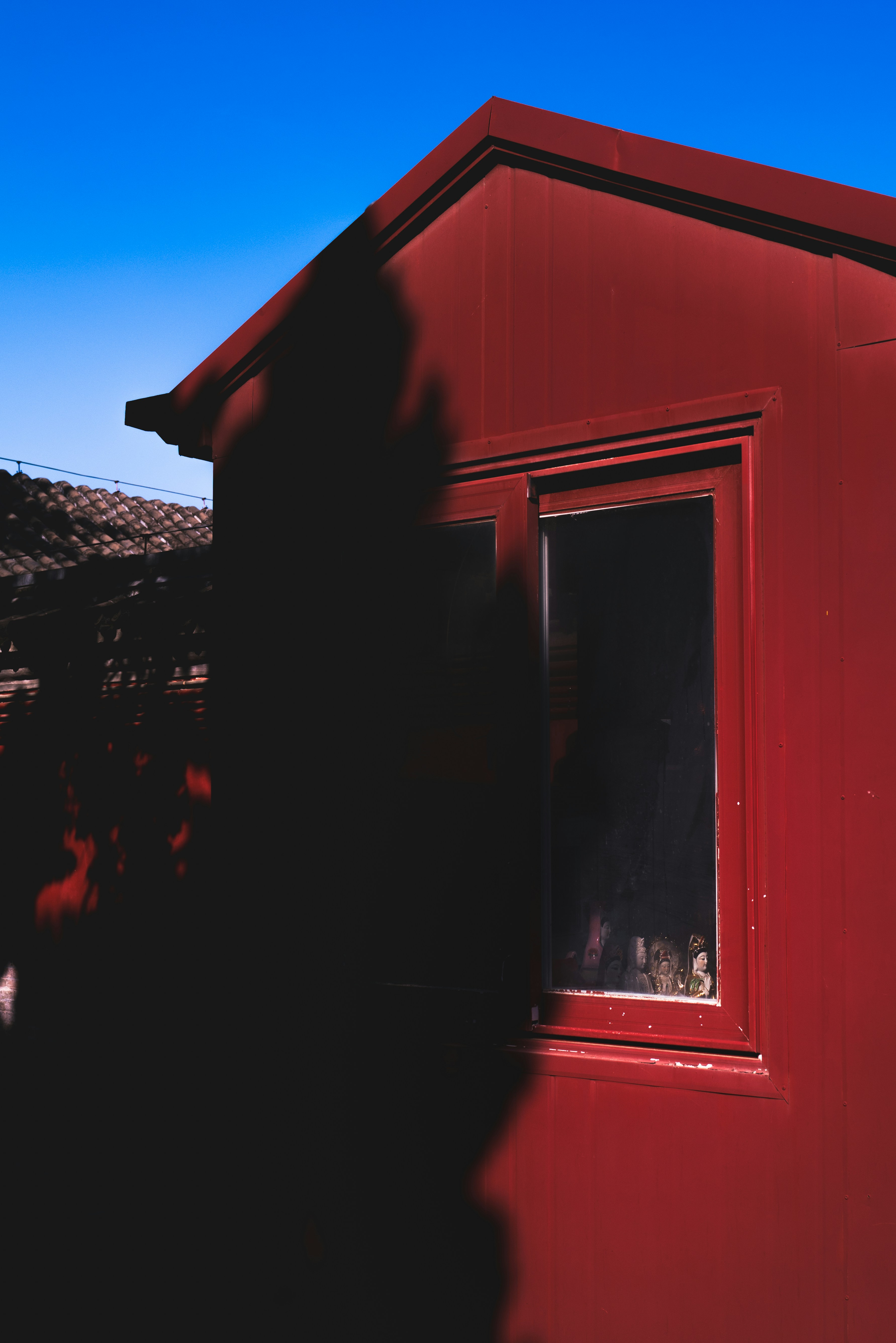 Crimson shed under a clear blue sky