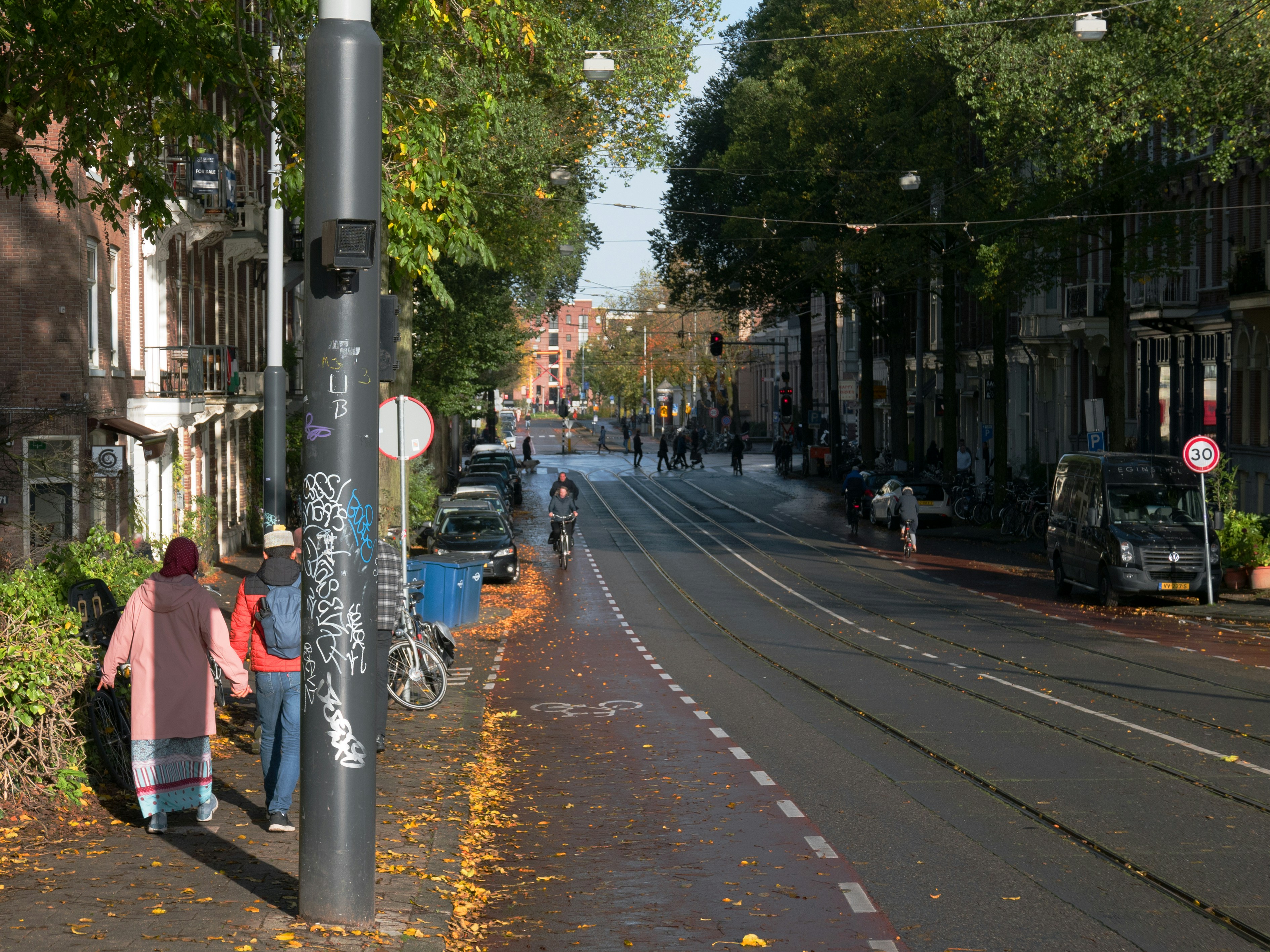 Autumn Streetcar Pause: Pedestrians and Painted Poles