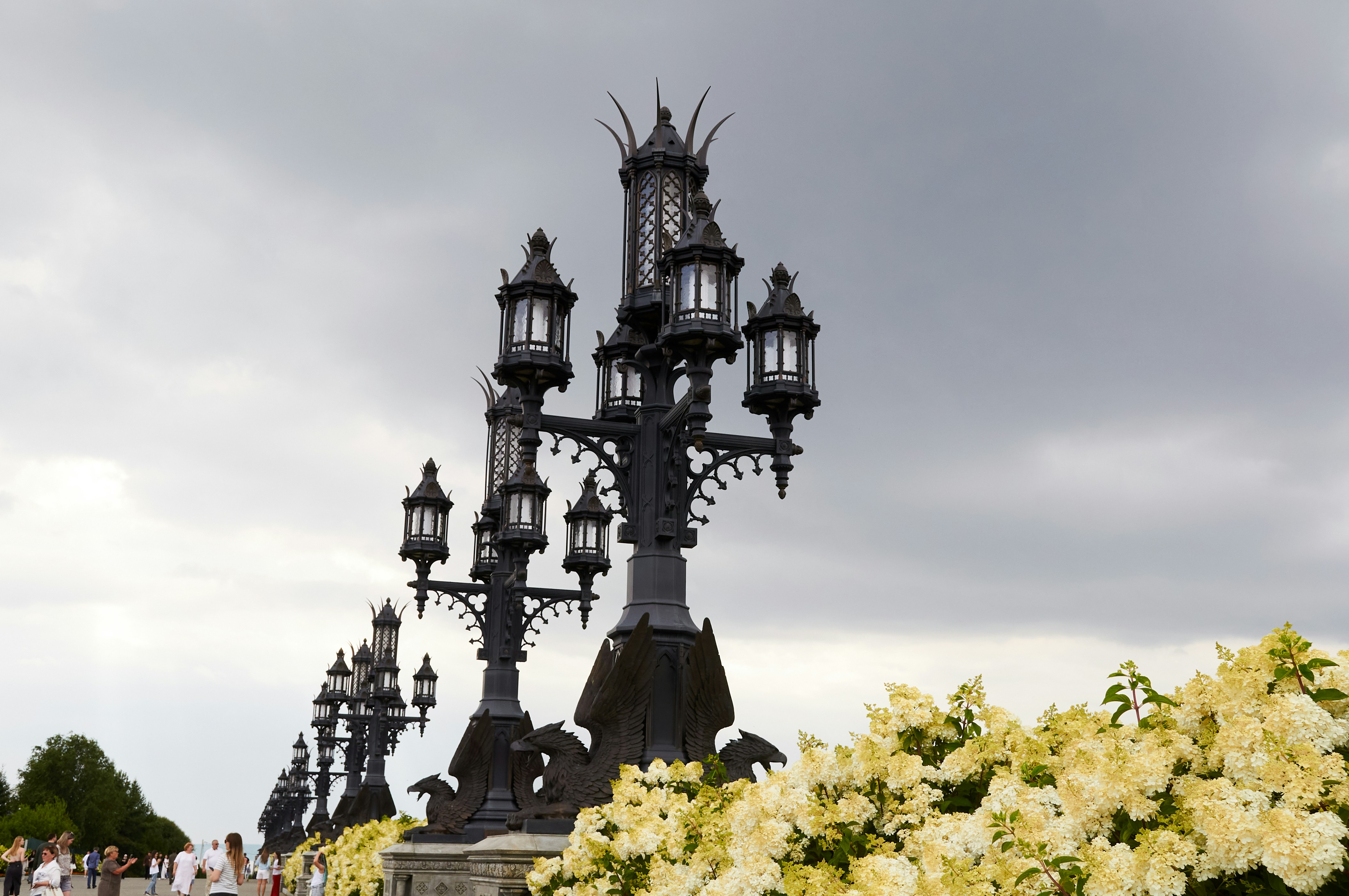 Ornate Lamppost Cascade on a Blooms–Fringed Bridge