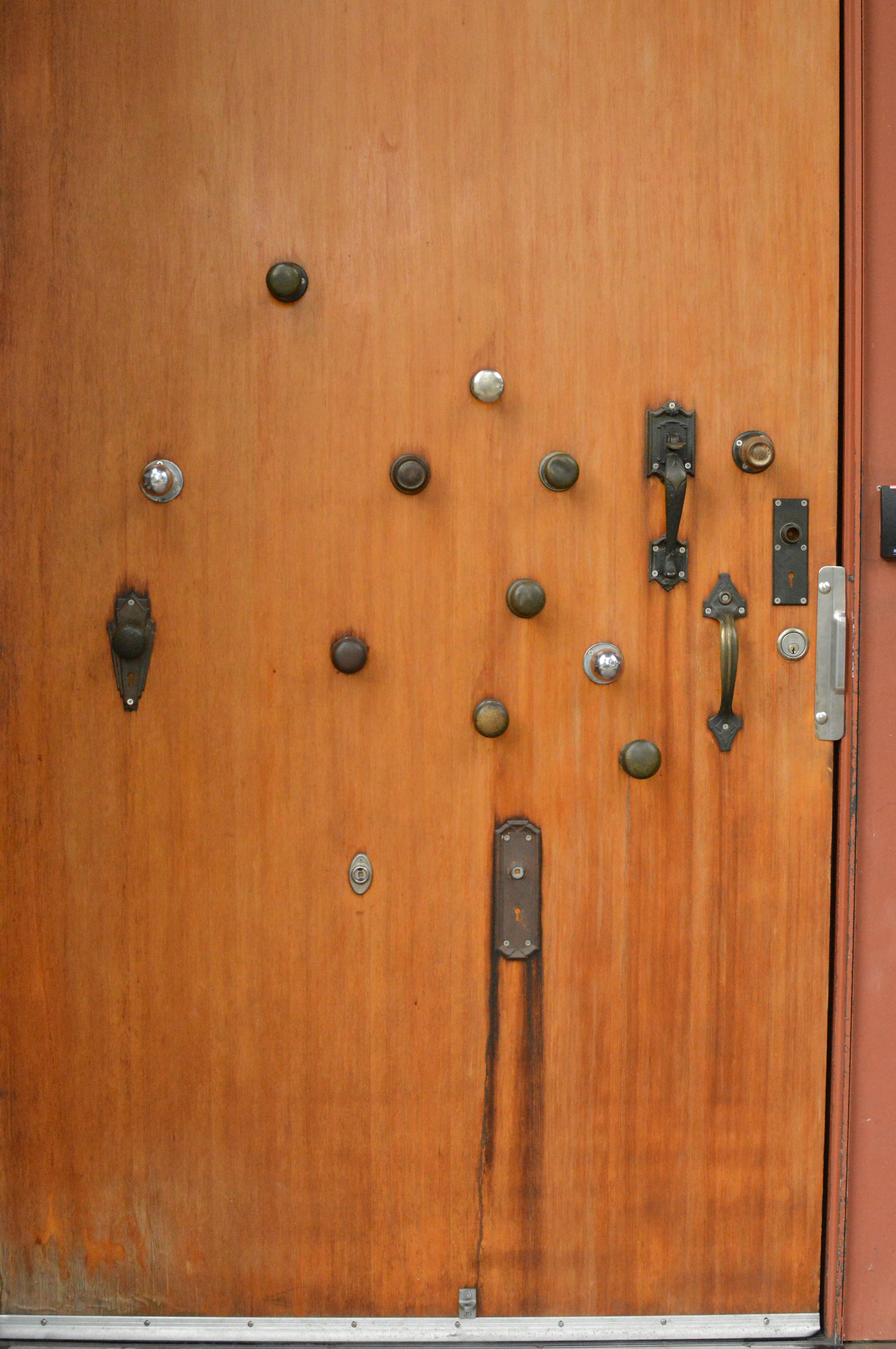 Weathered Knobs and Ironwork on a Wooden Door