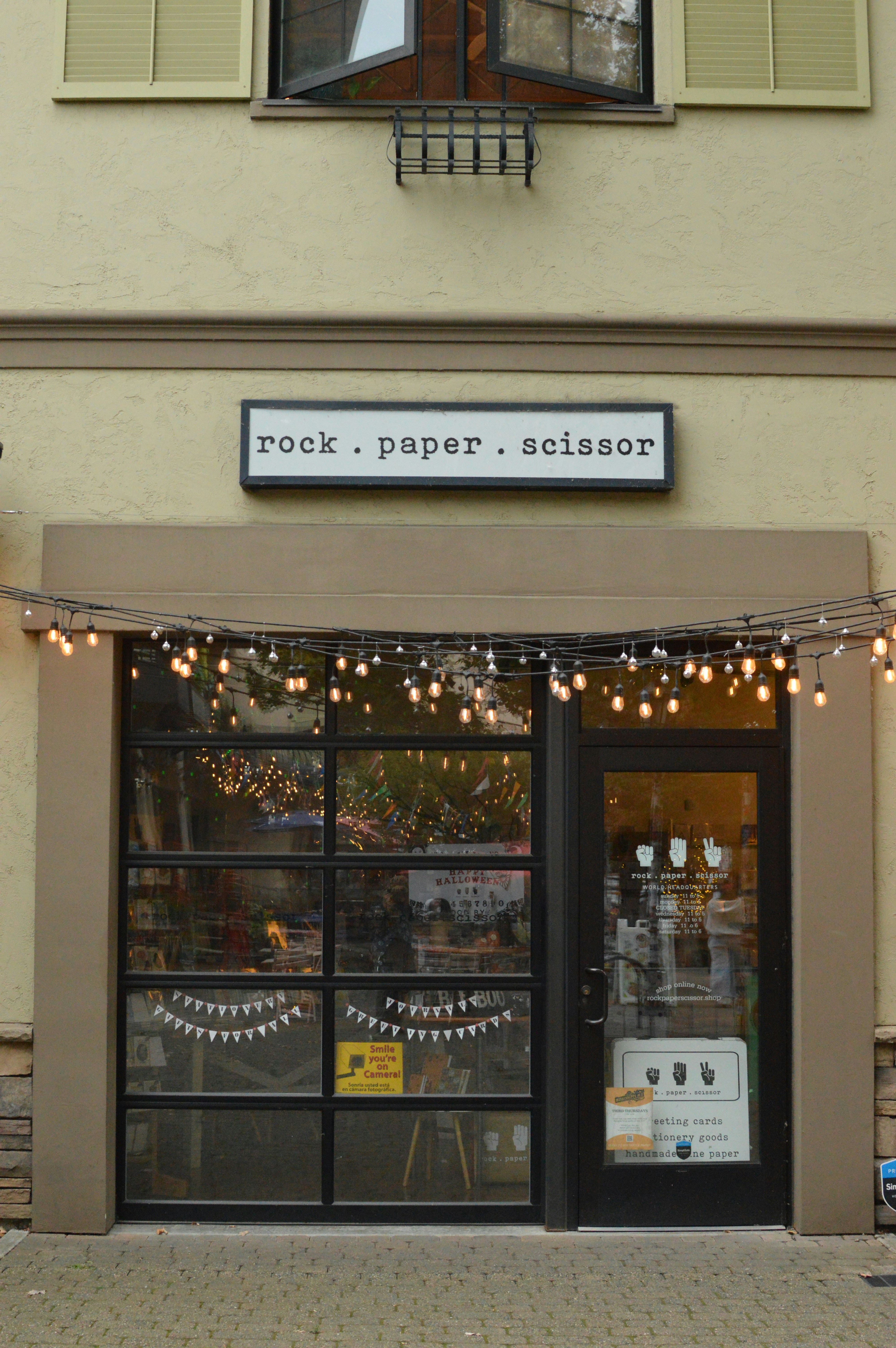 String lights glow over a cozy storefront sign