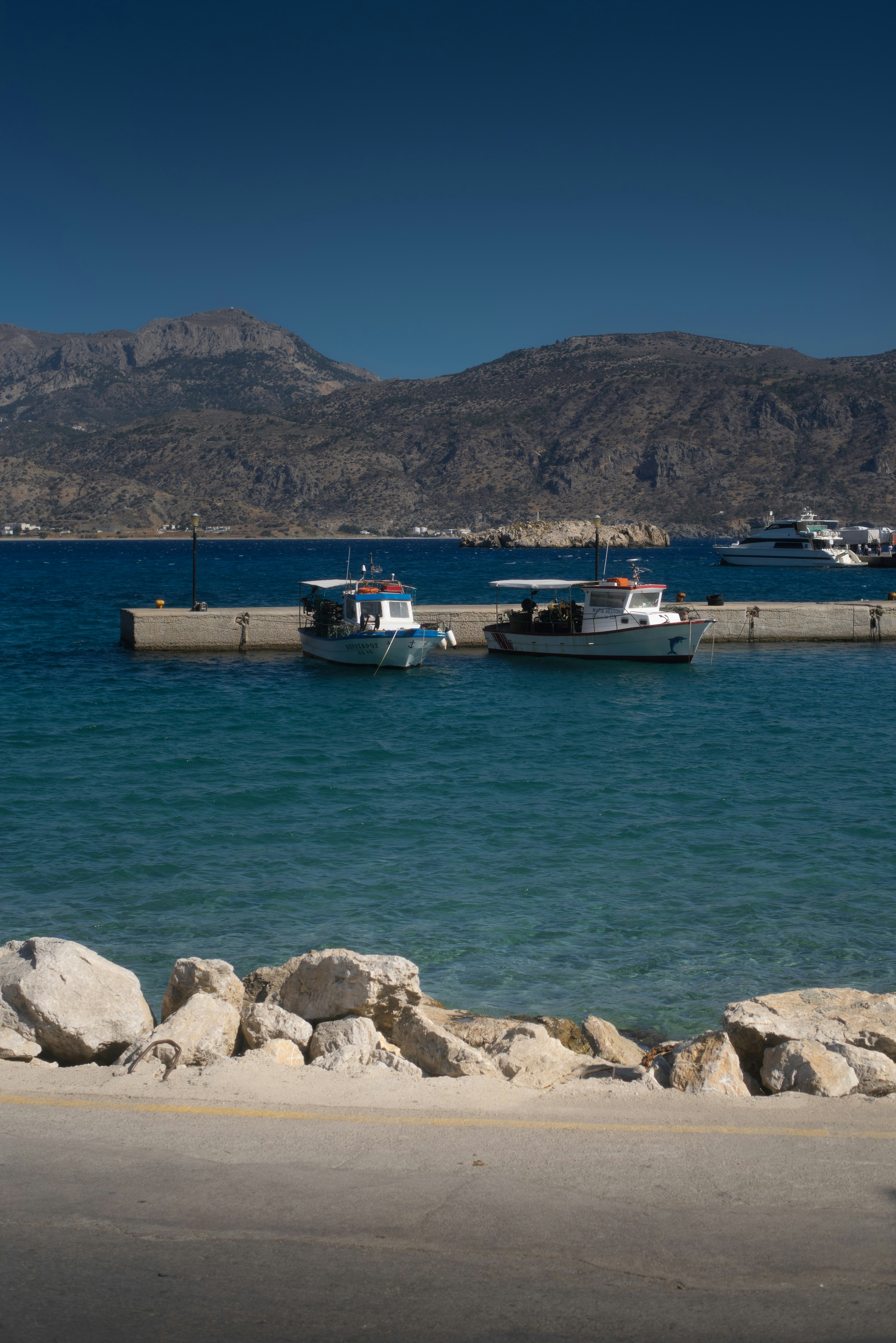 Harbor Light: Boats at the Breakwater Beneath Coastal Mountains