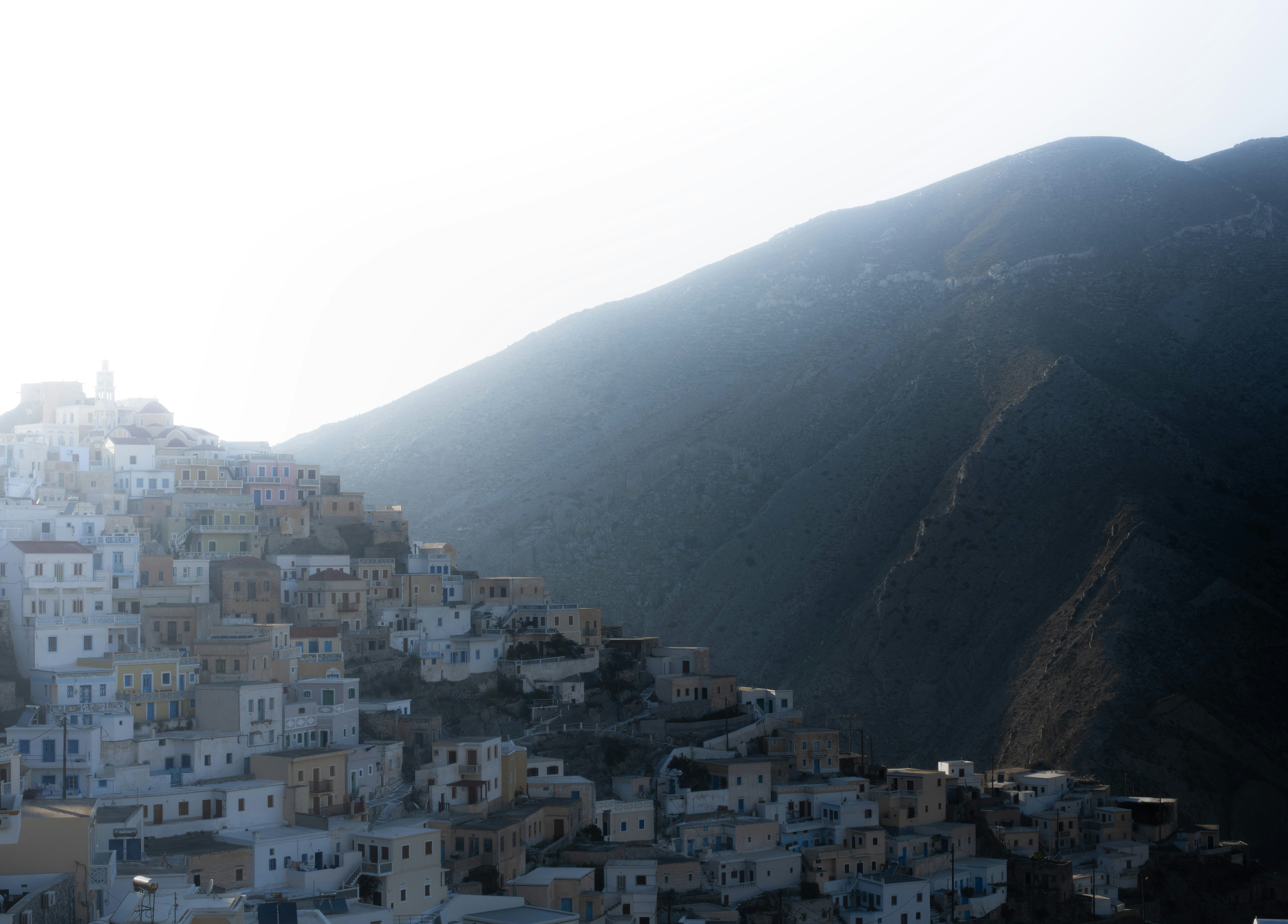 Terraced village at the edge of a shadowed cliff