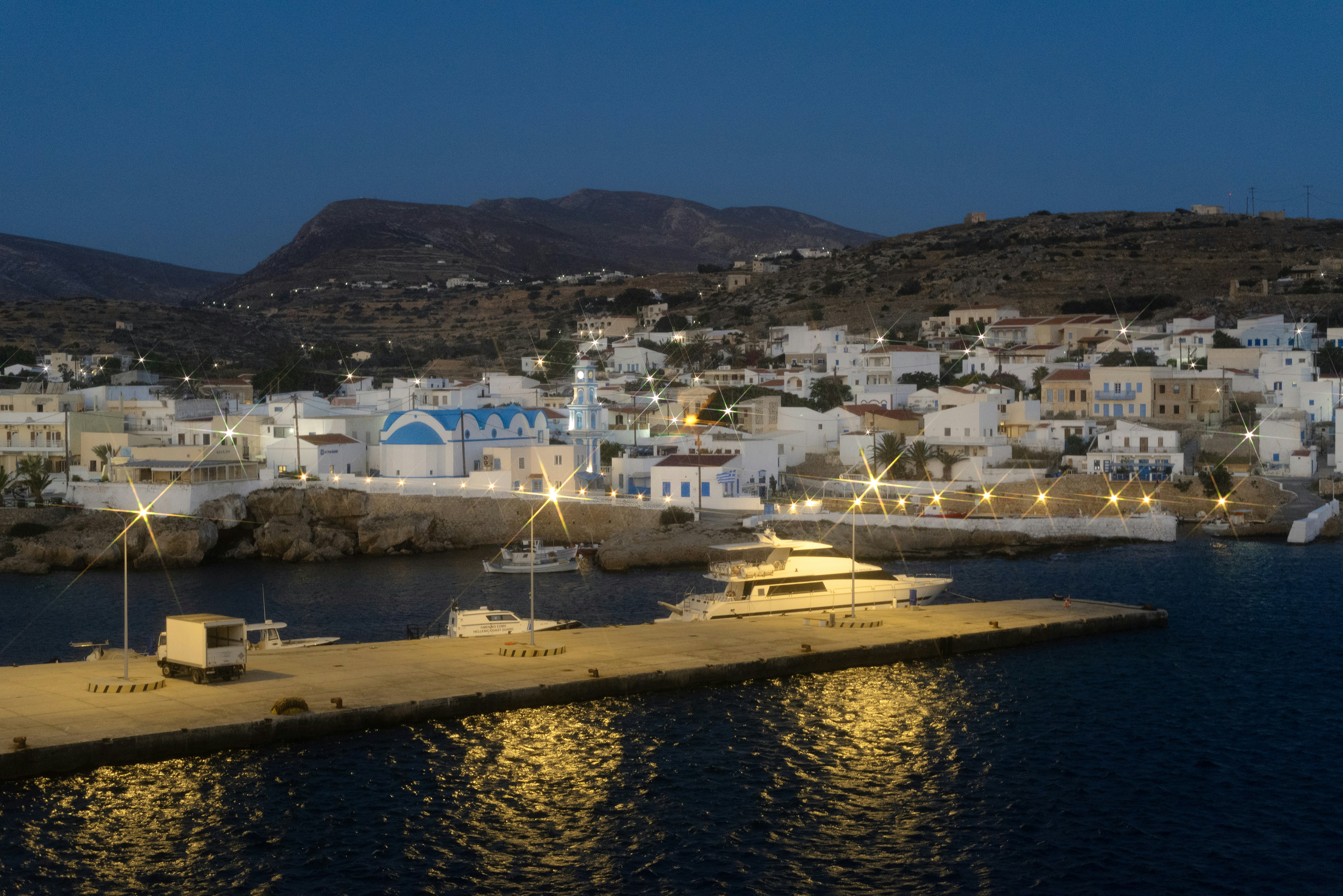 Harbor Lights Over a White-Washed Cycladic Village at Dusk