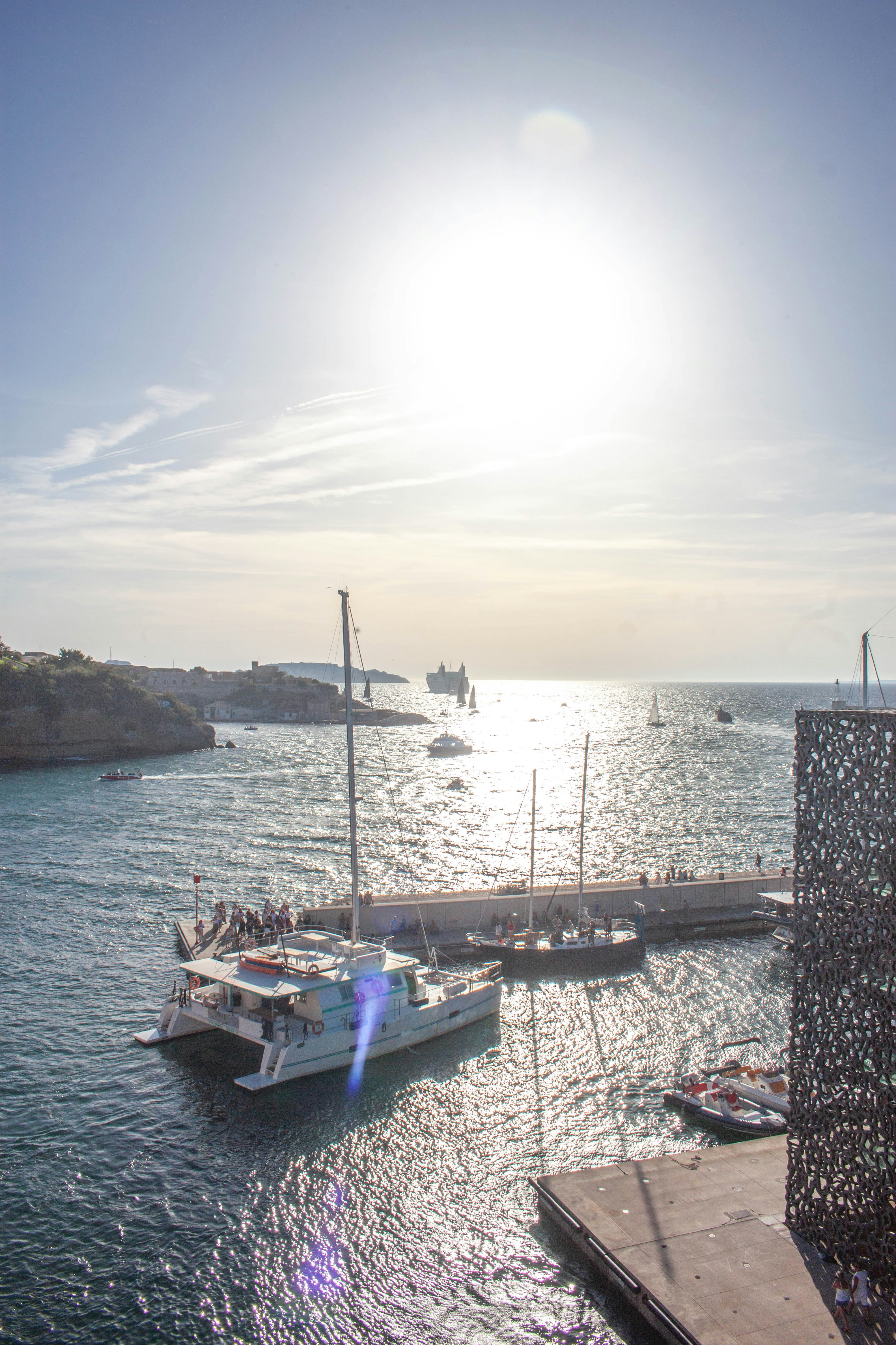Harbor Light at Zenith: Boats Rest by a Sunlit Sea
