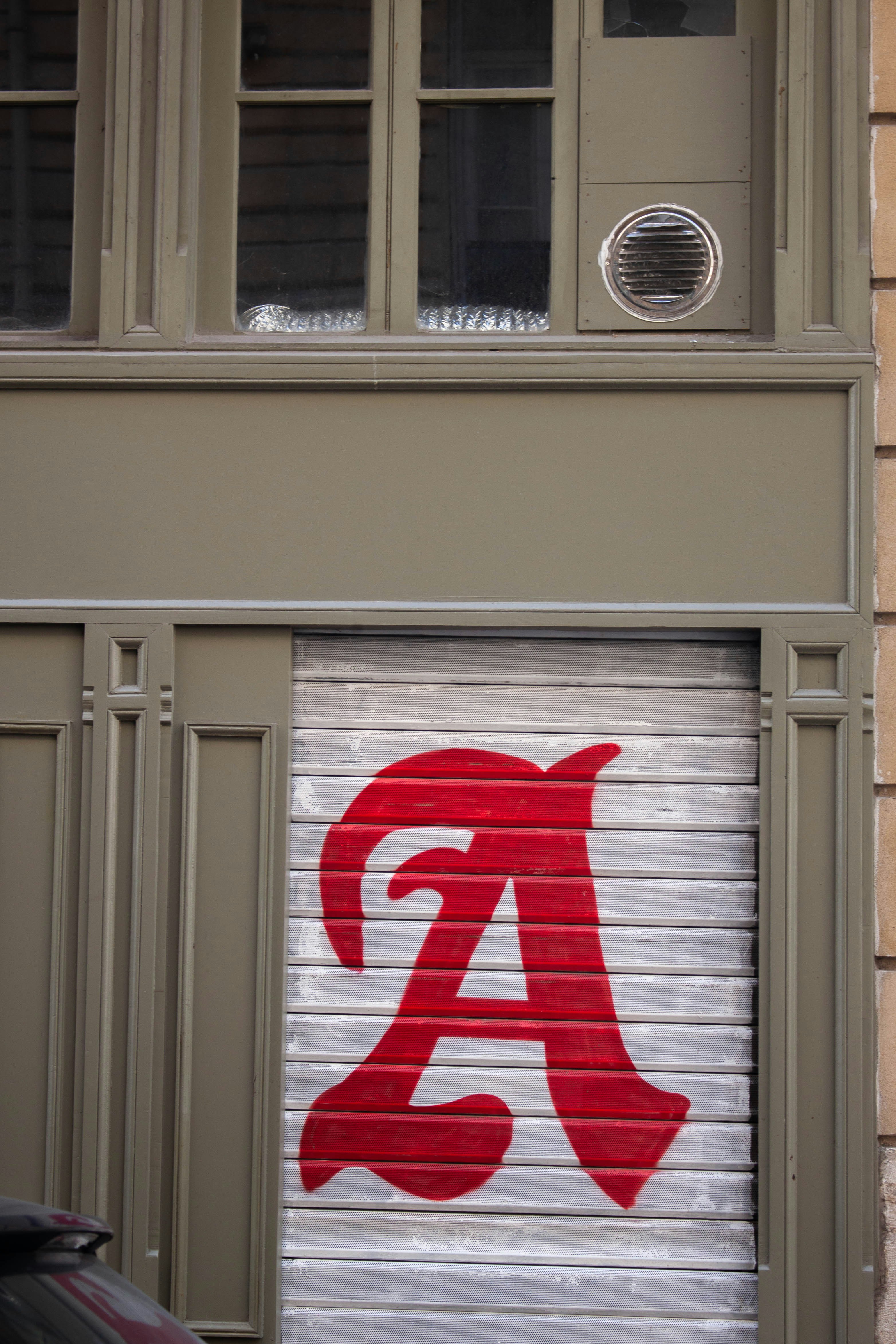 A Red A Emerges from the Metal Garage Door