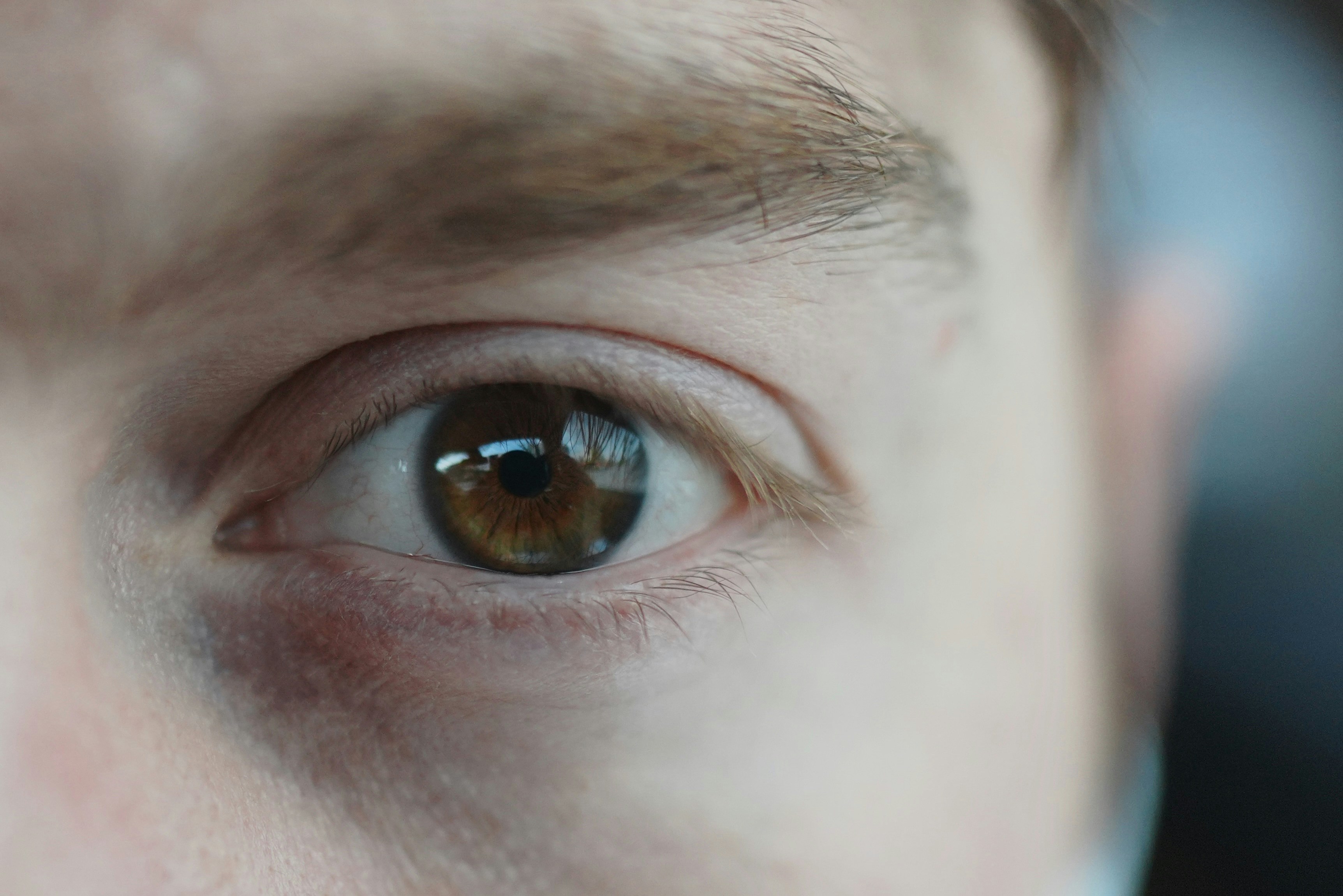 Close-Up Gaze: A Brown Eye with Gentle Light and Subtle Skin Texture
