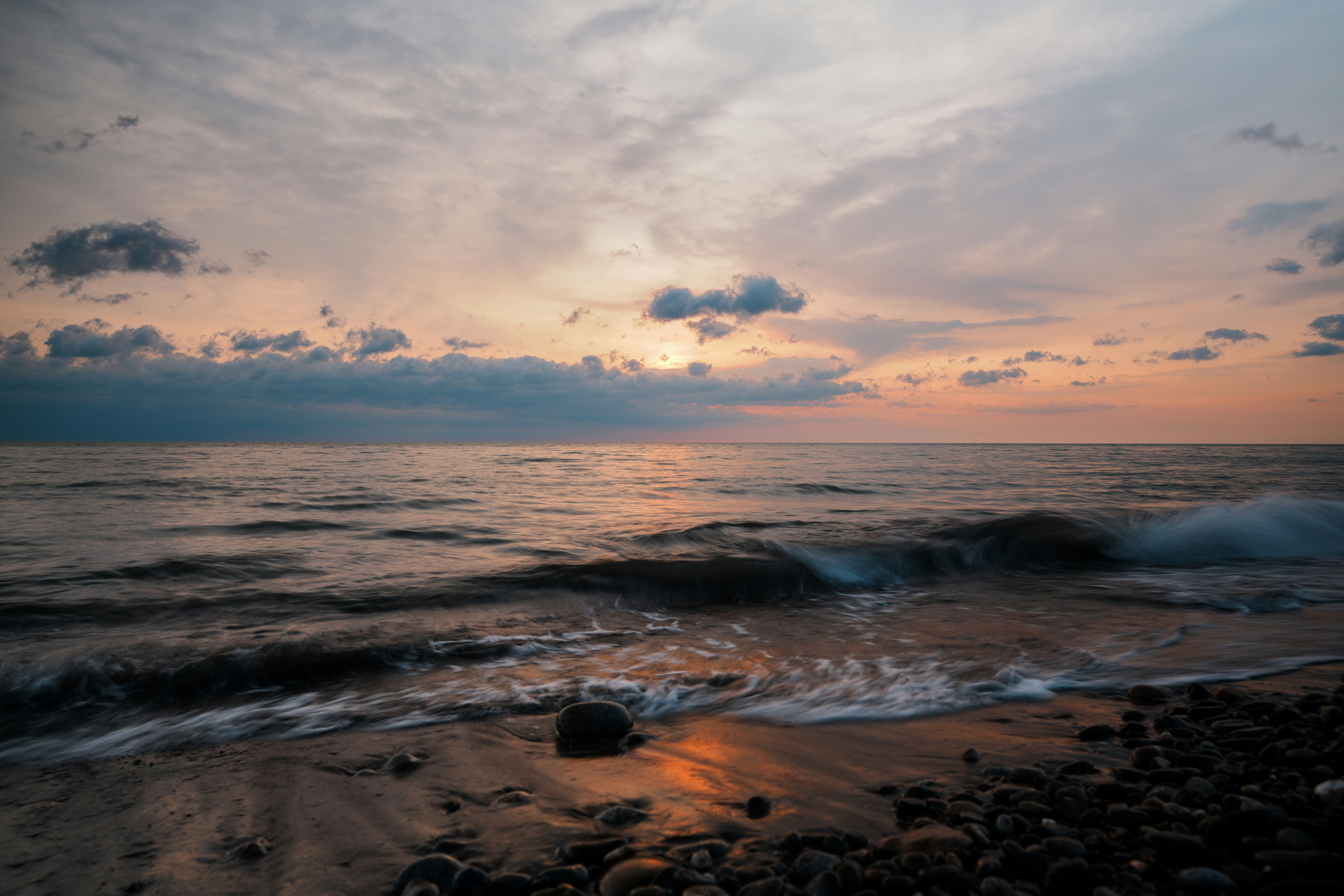 Dusk on the Pebble Shore: Gentle Waves and a Quiet Horizon