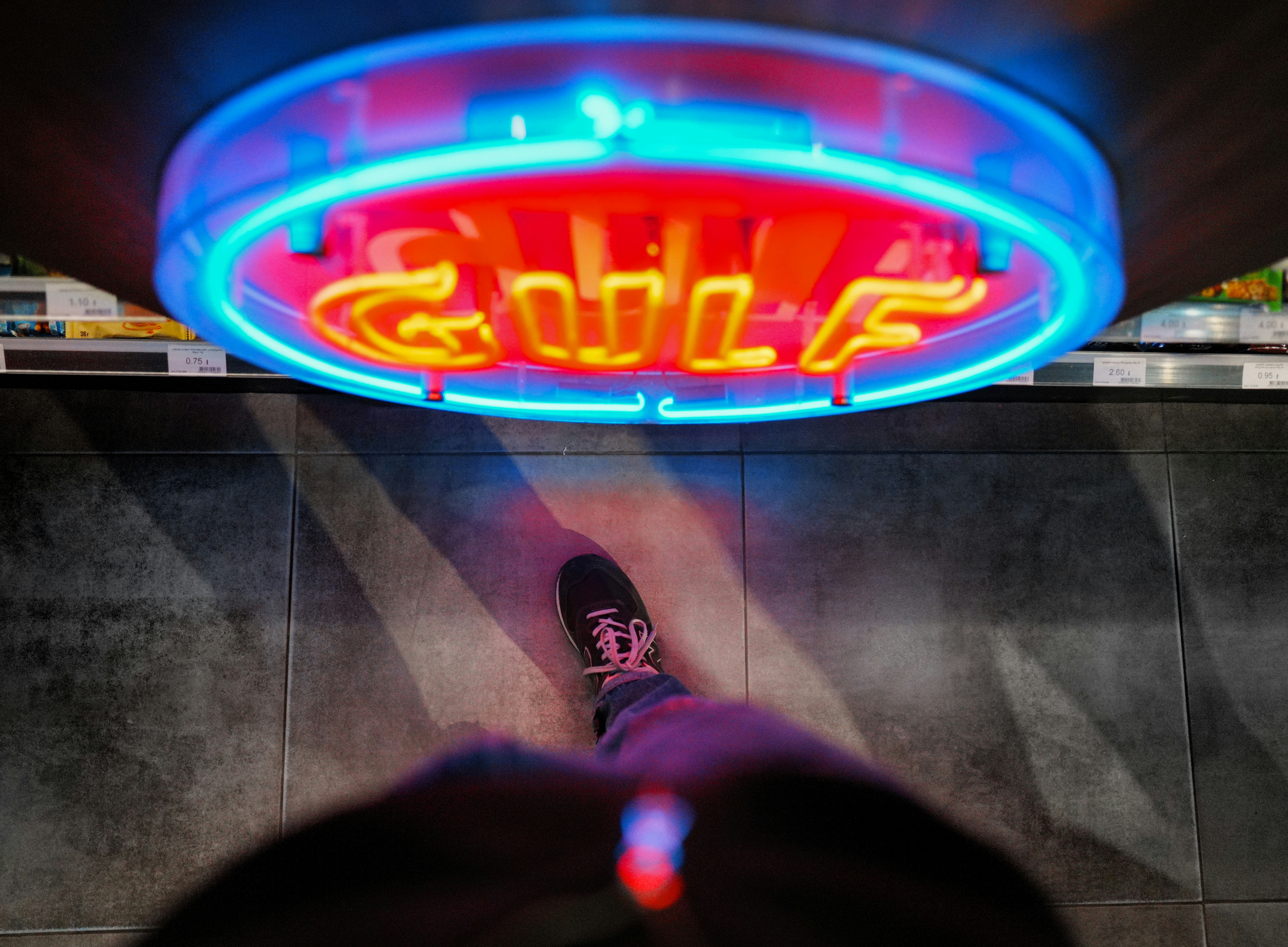 Neon Ring of Footsteps: Glowing Sign Above a Shopper's Footstep
