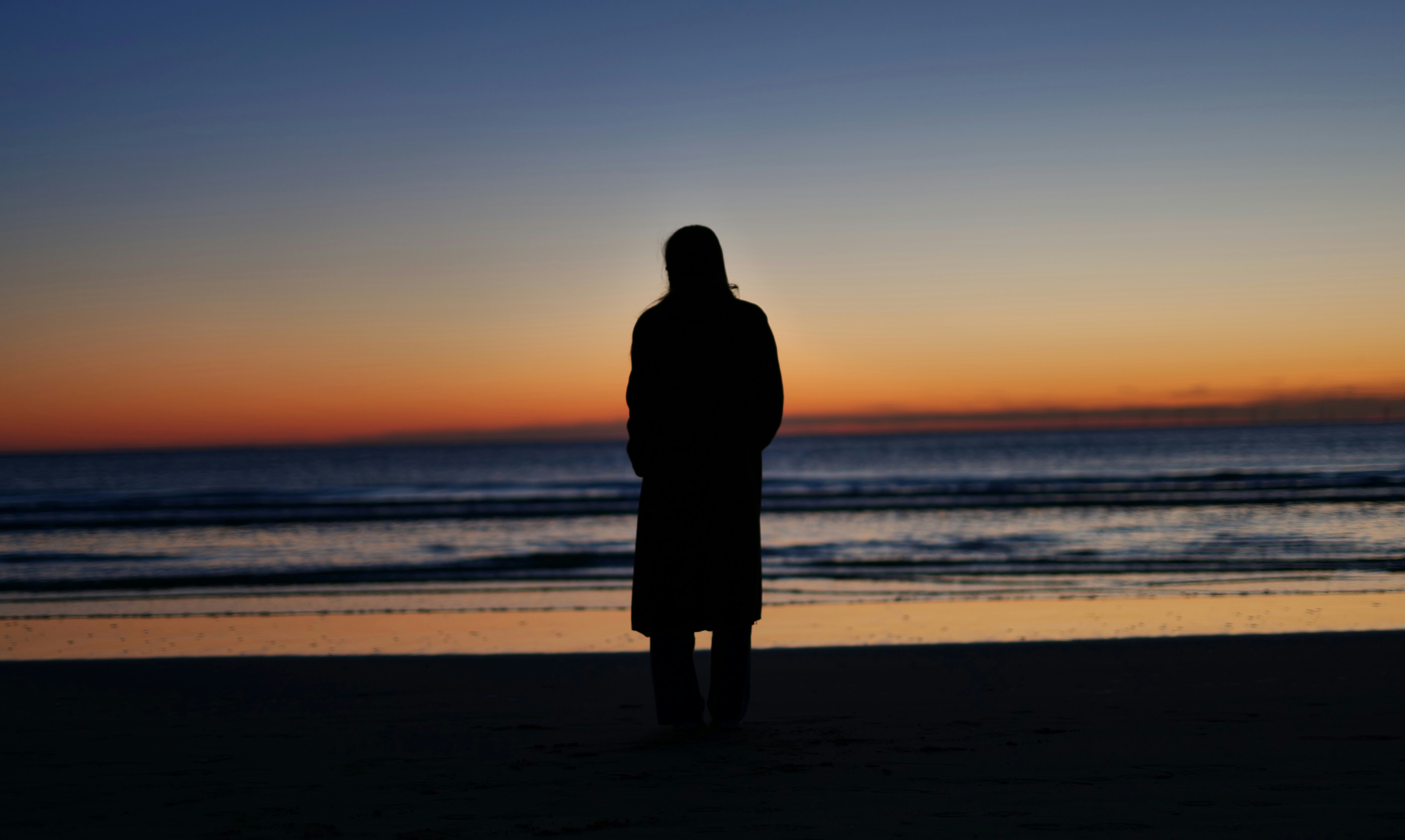 Silhouette at Dusk: A Quiet Watch by the Sea