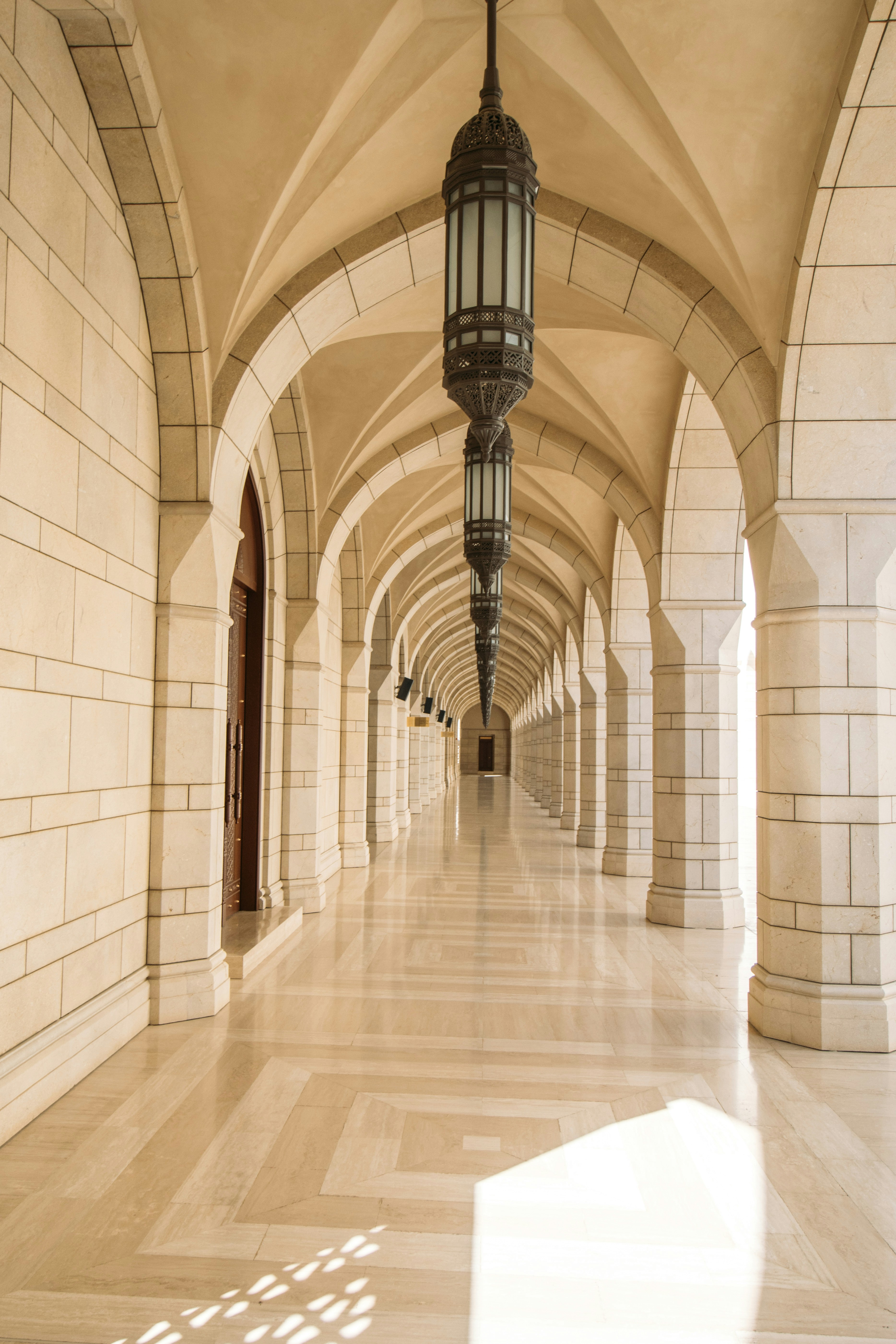 Architectural Odyssey: Light, Arches, and Lanterns in a Marble Corridor
