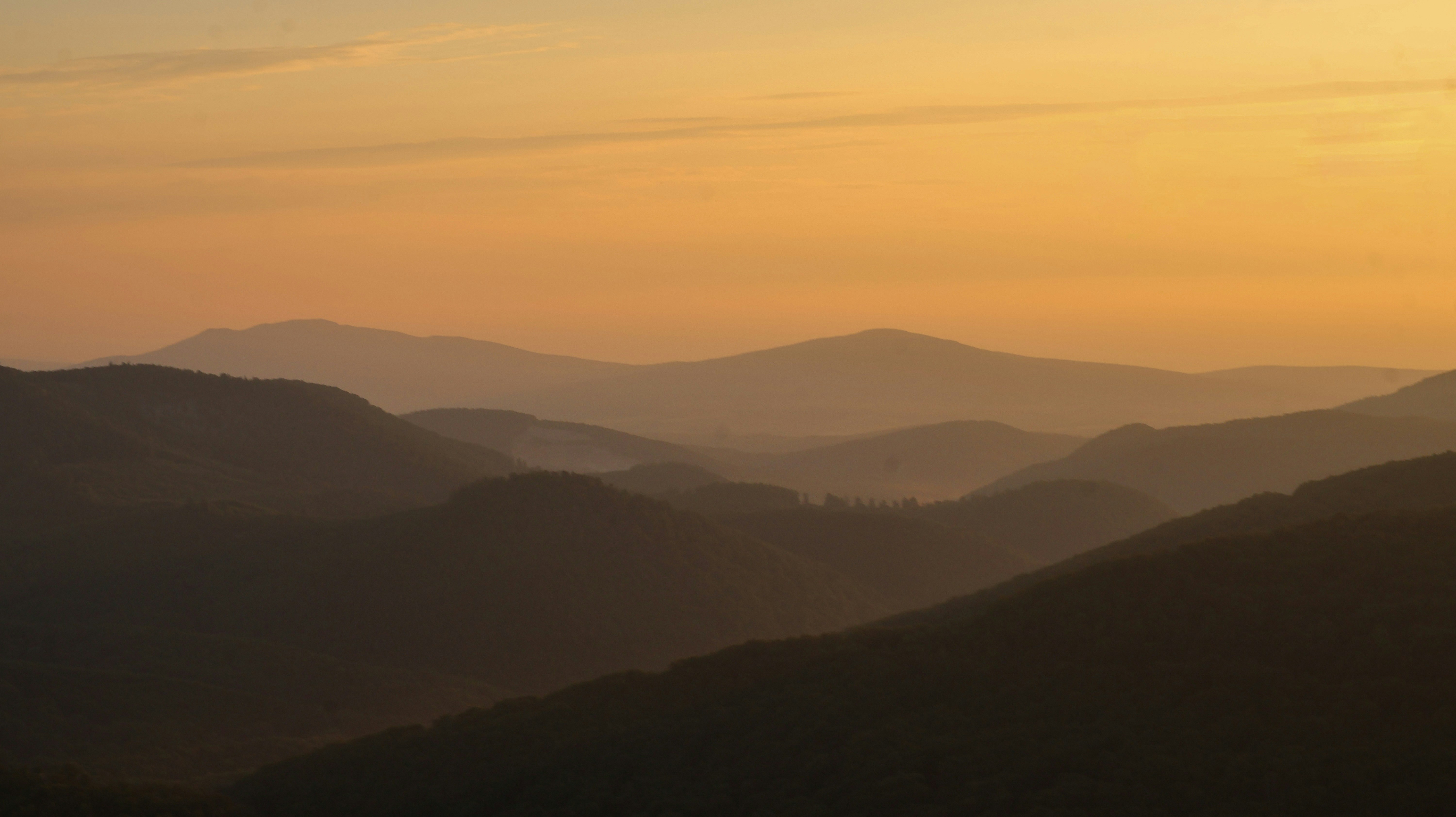 Hazy Ridgeline at Golden Hour Over Rolling Hills