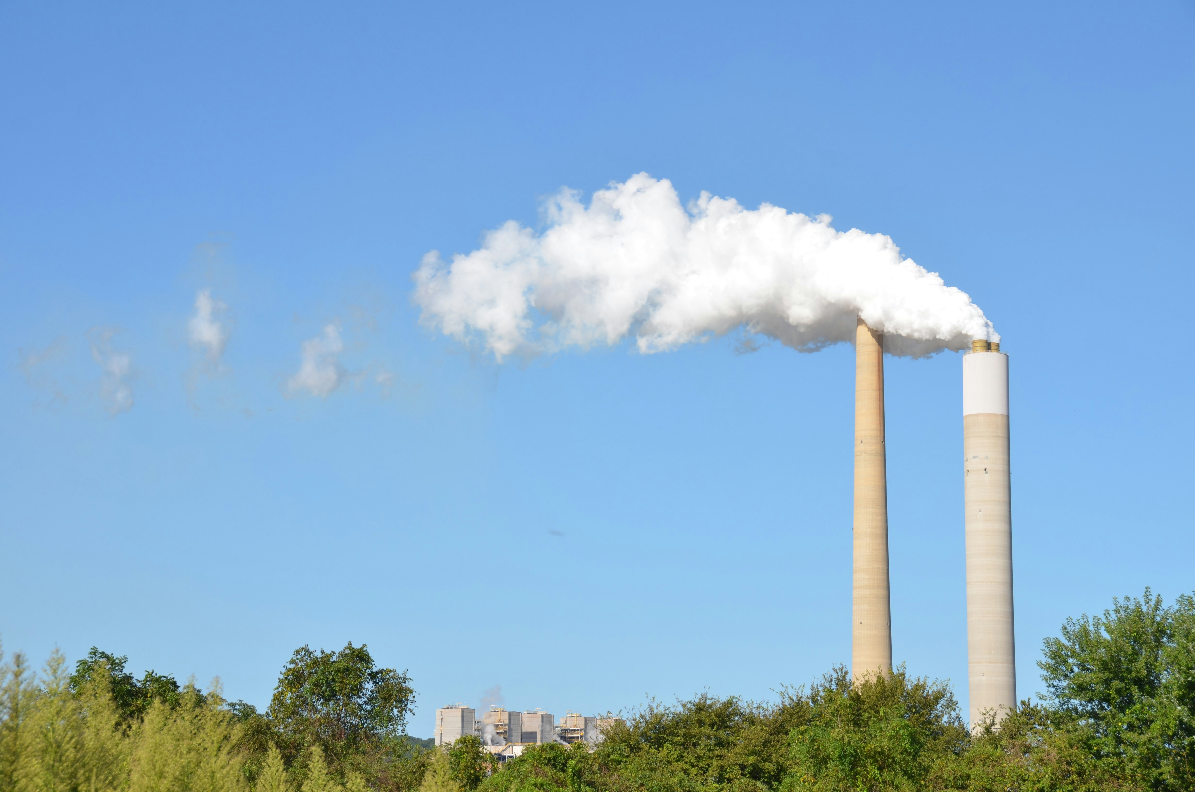 Industrial Silhouette: Two Smokestacks Piercing a Clear Sky