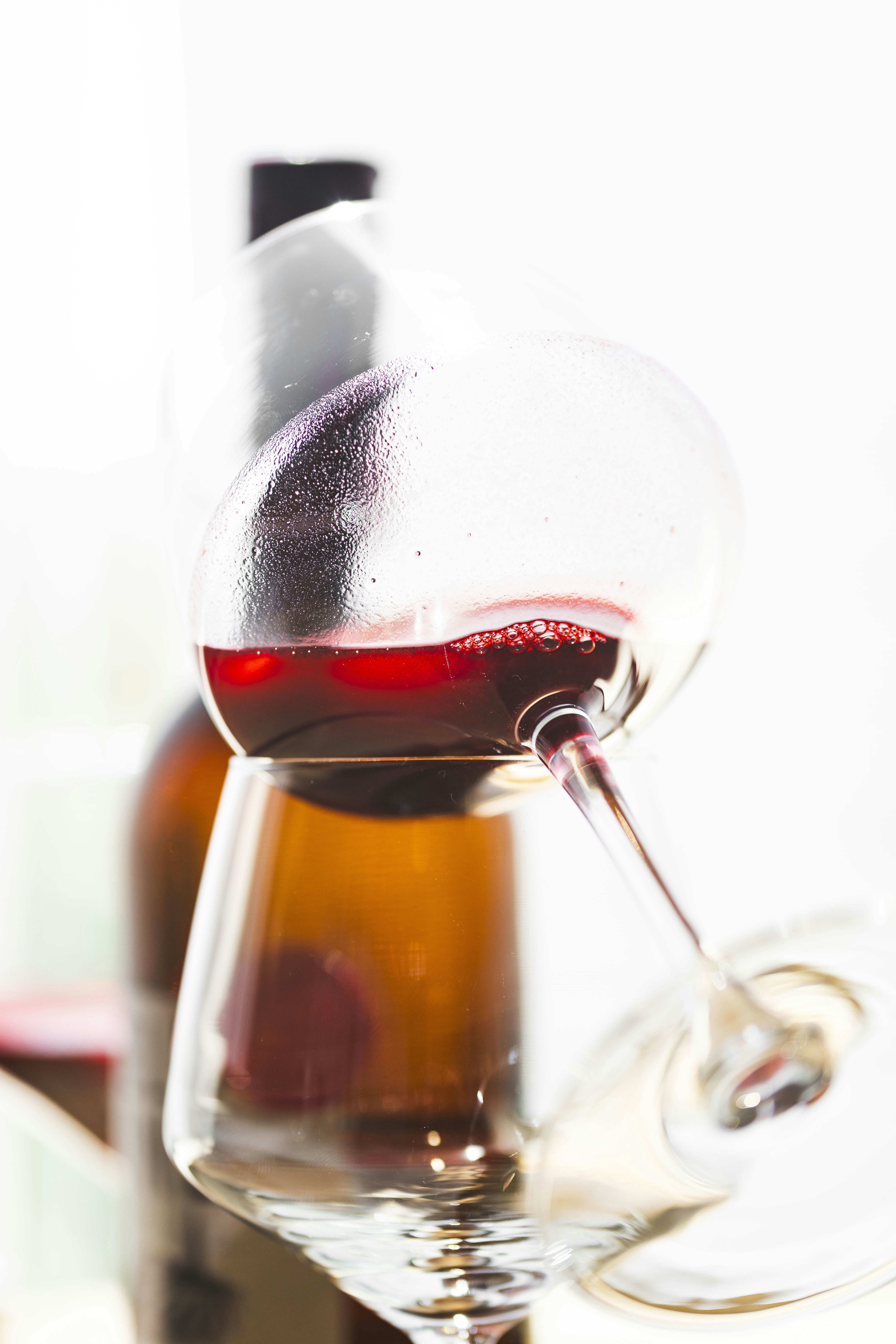 Aqua Refractions: Tilted Glass with Red Wine Cloud