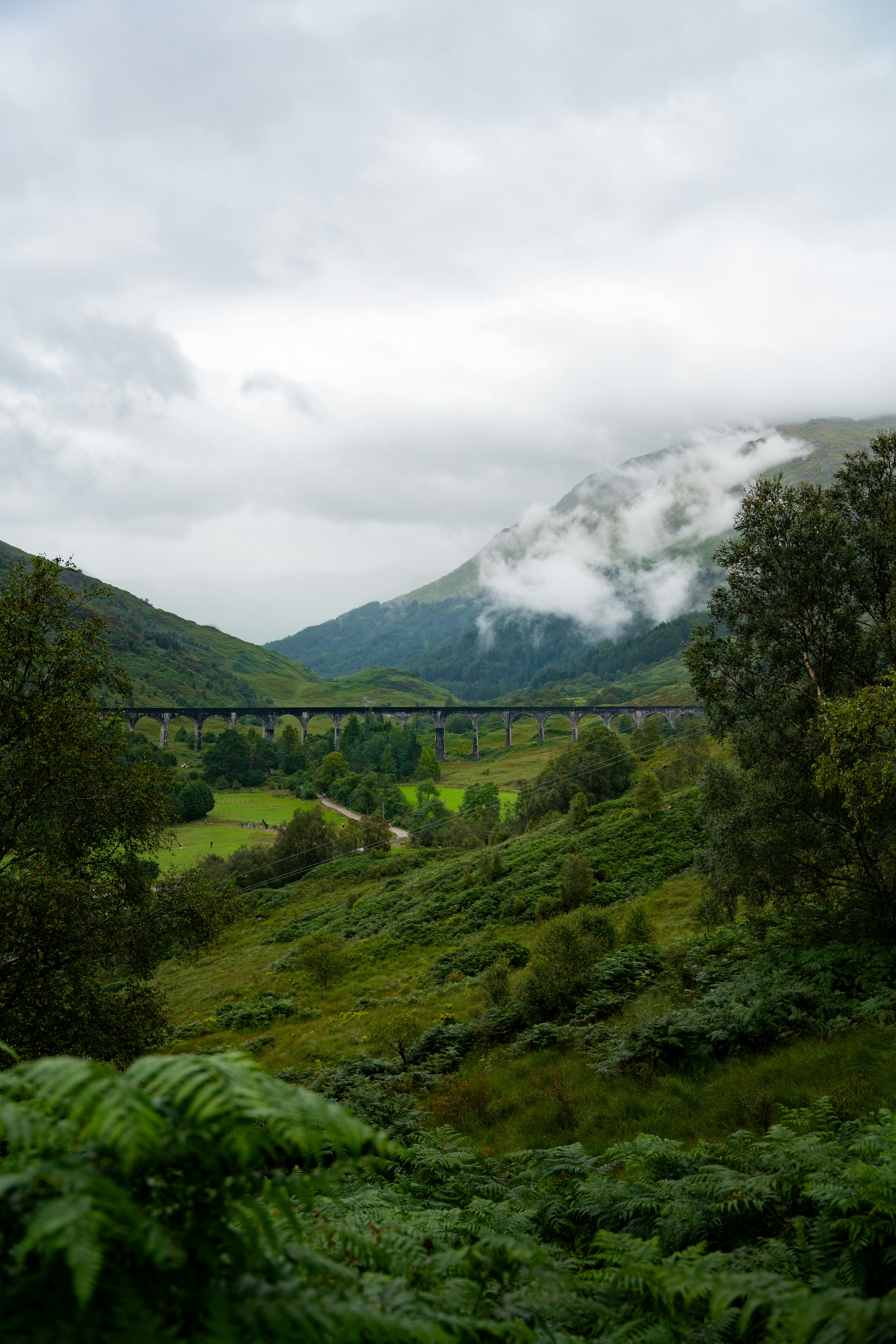 Rustic Viaduct in a Rolling green Valley under Misty Peaks
