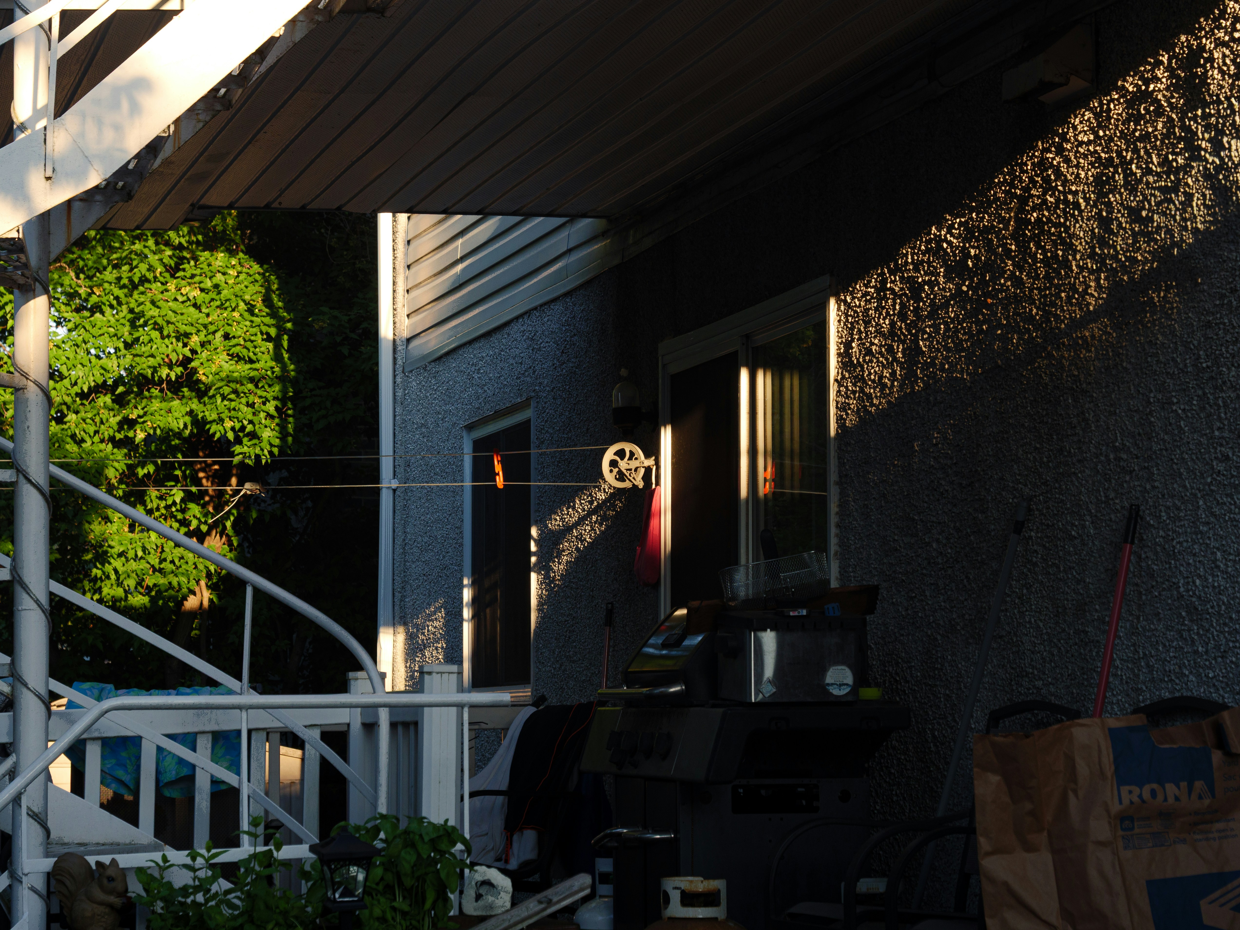 Sunlit Corner: Backstairs, Shadowed Facade and a Quiet Satchel