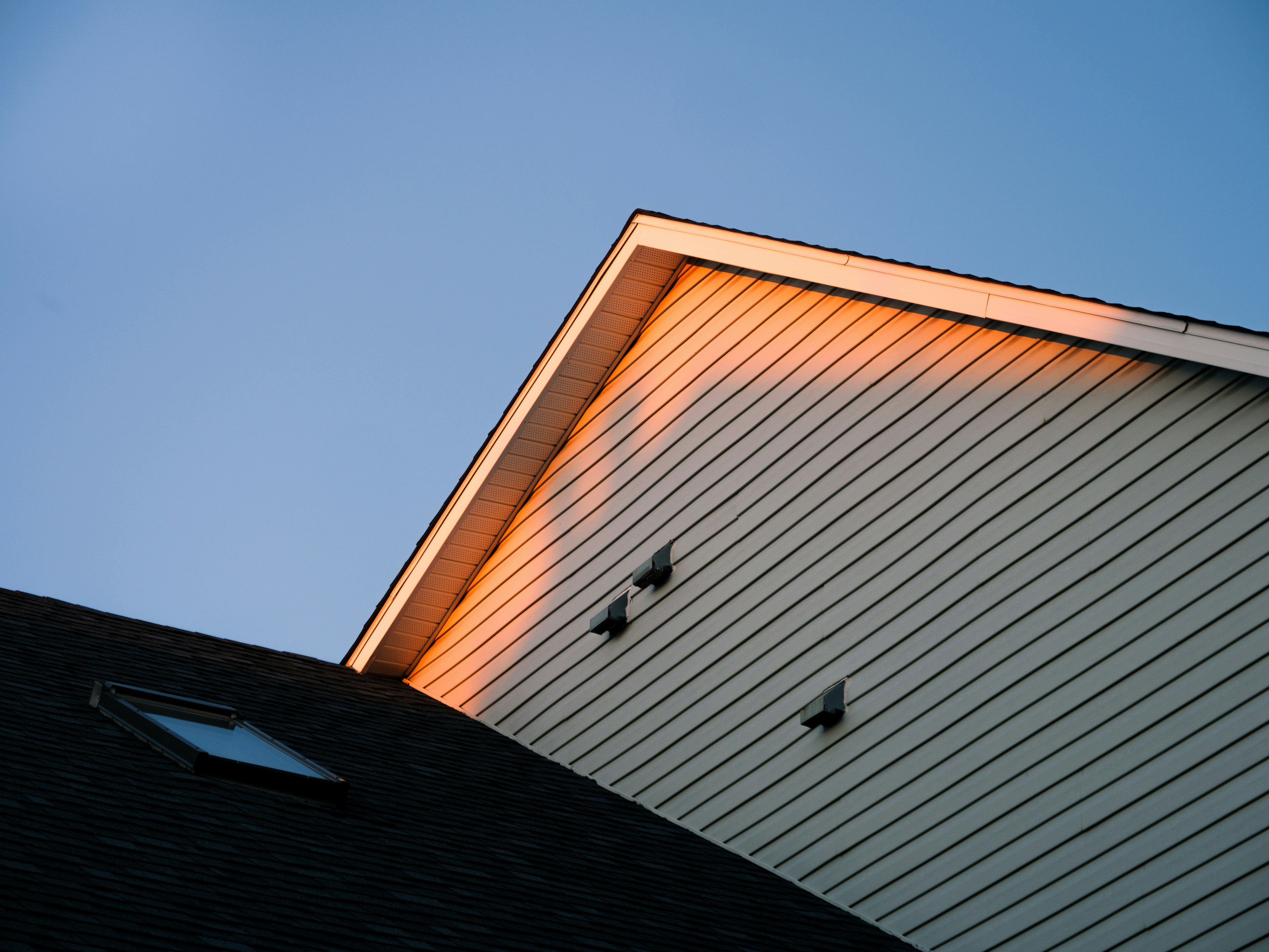 Rising Roofline at Dusk: A Gently Lit Facade Against a Clear Sky