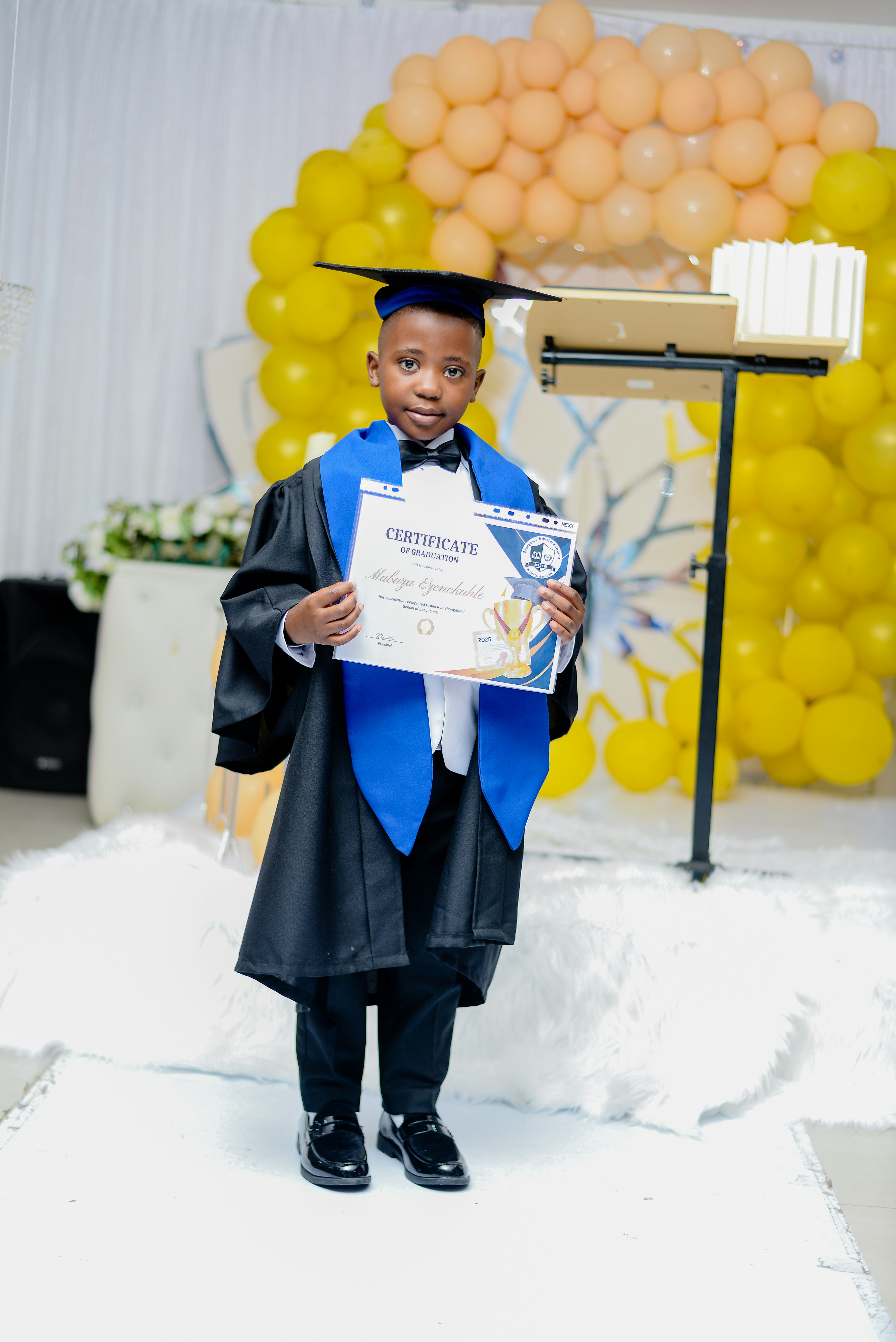 Graduation Glow: A Young Scholar Holds His Certificate on Stage