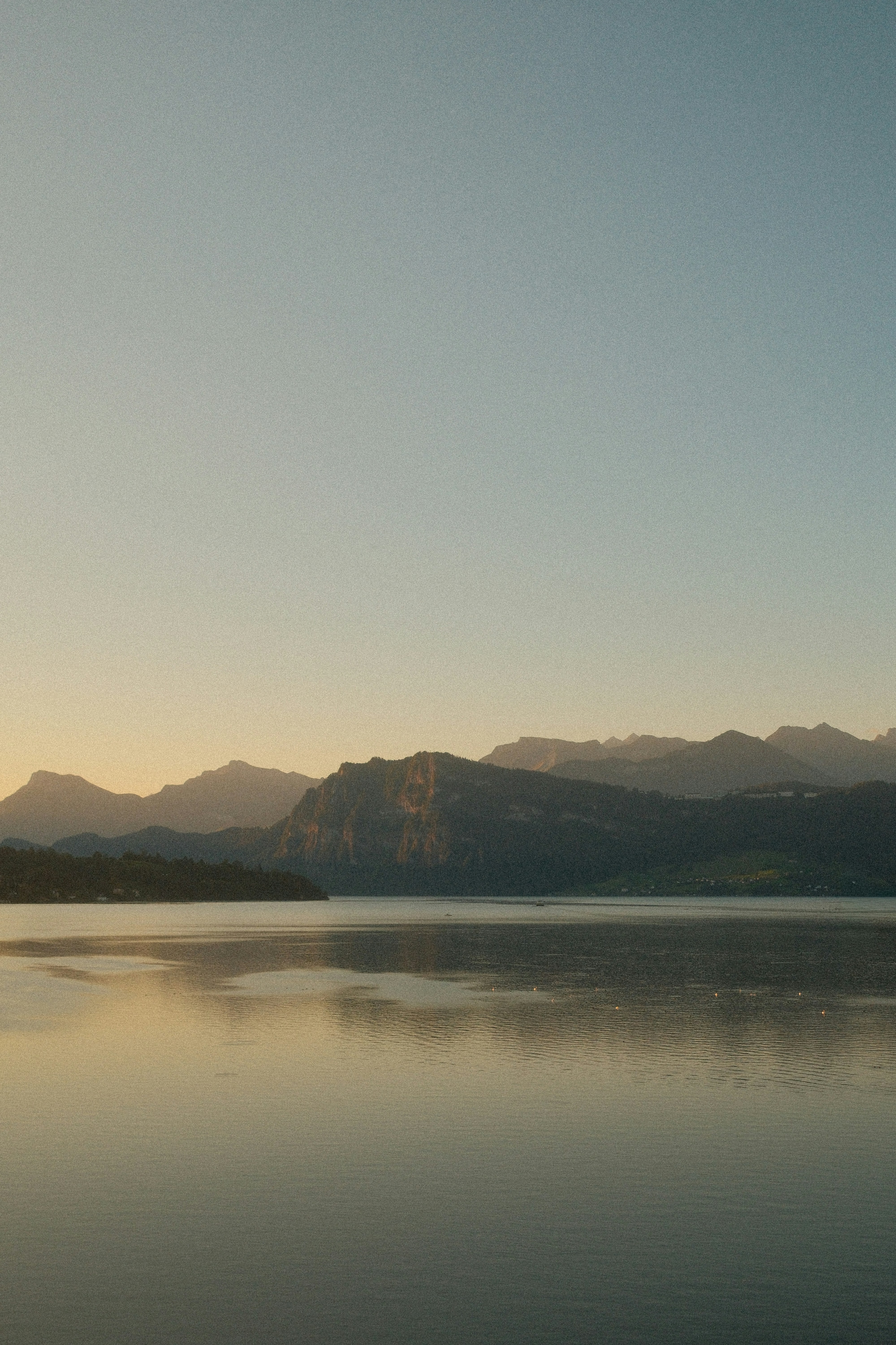 Distant Peaks Over a Quiet Glacial Lake at Dusk