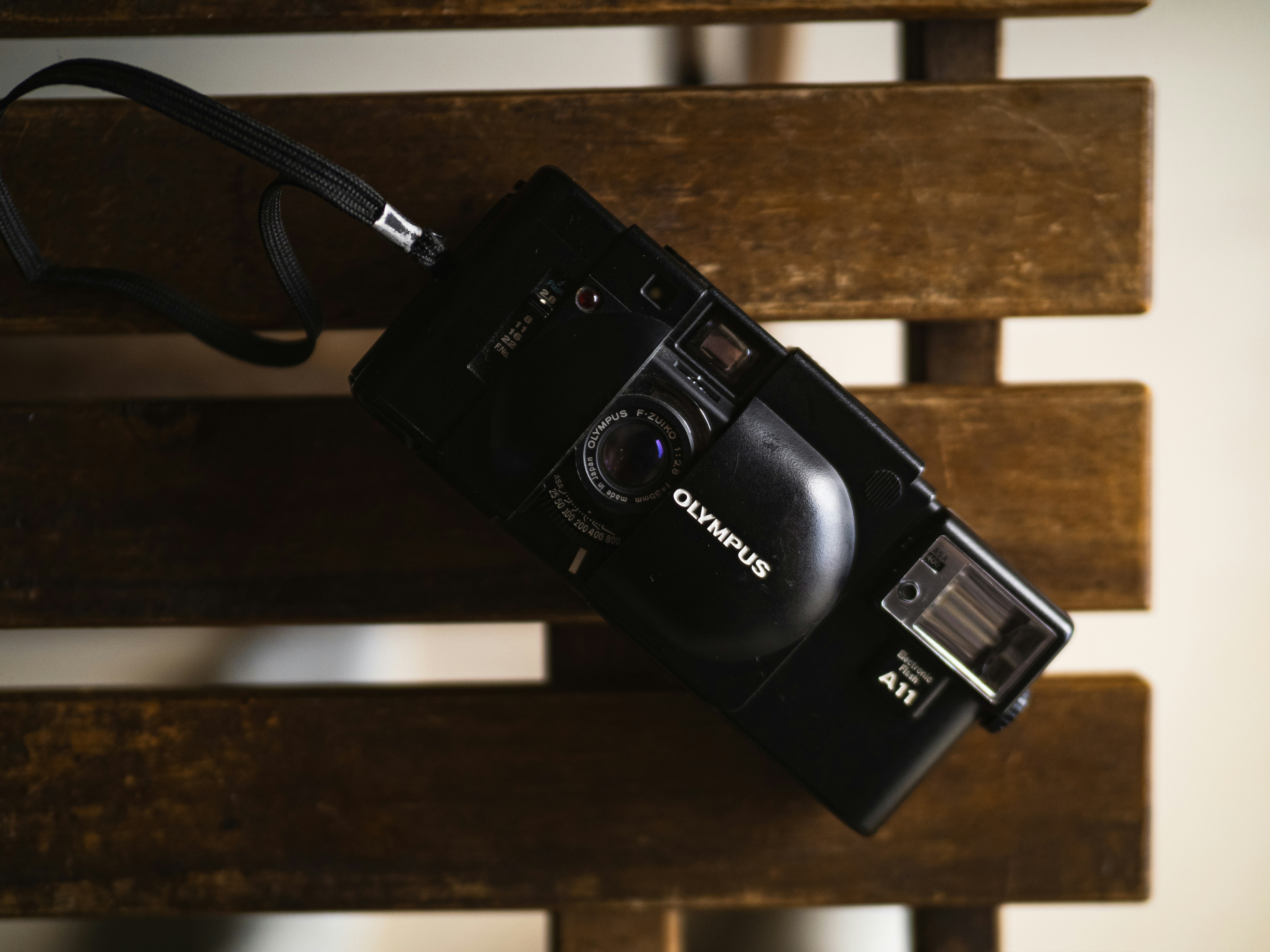 Retro Olympus: A Close-Up of a Legacy Camera Resting on Weathered Wood