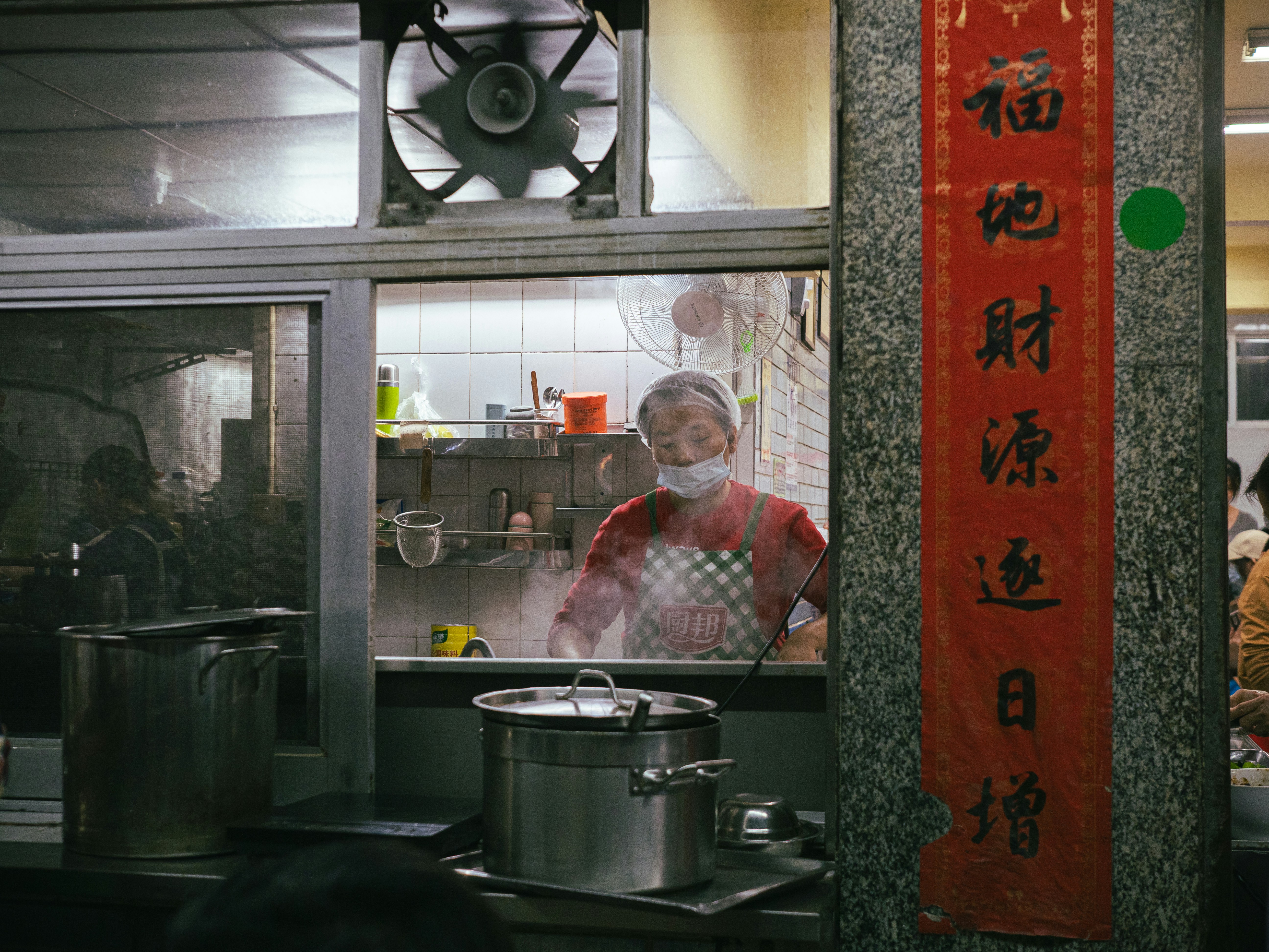 Mask-wearing Cook Through the Kitchen Window