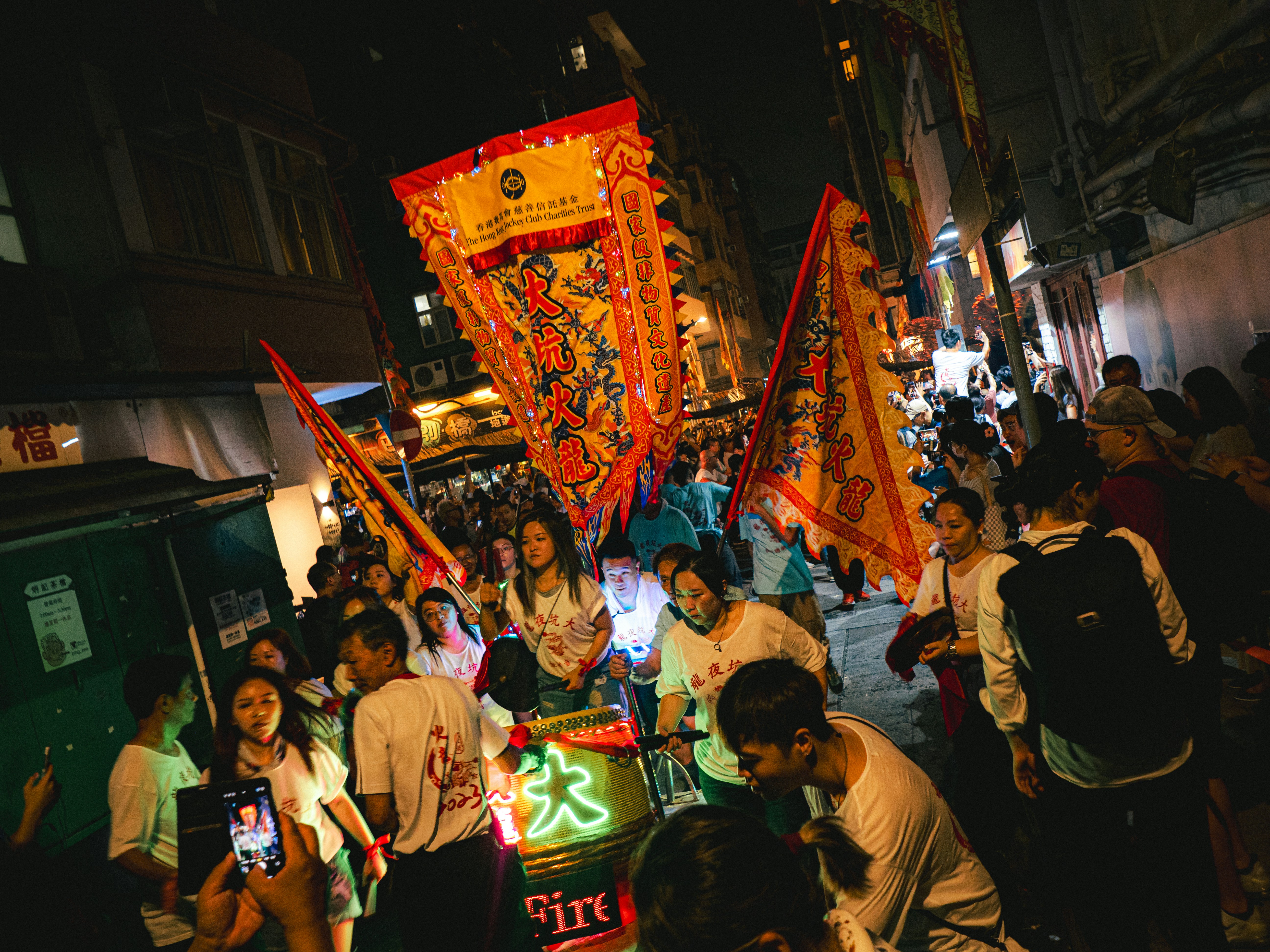 Lanterns and banners: A crowded night parade through a lantern-lit street