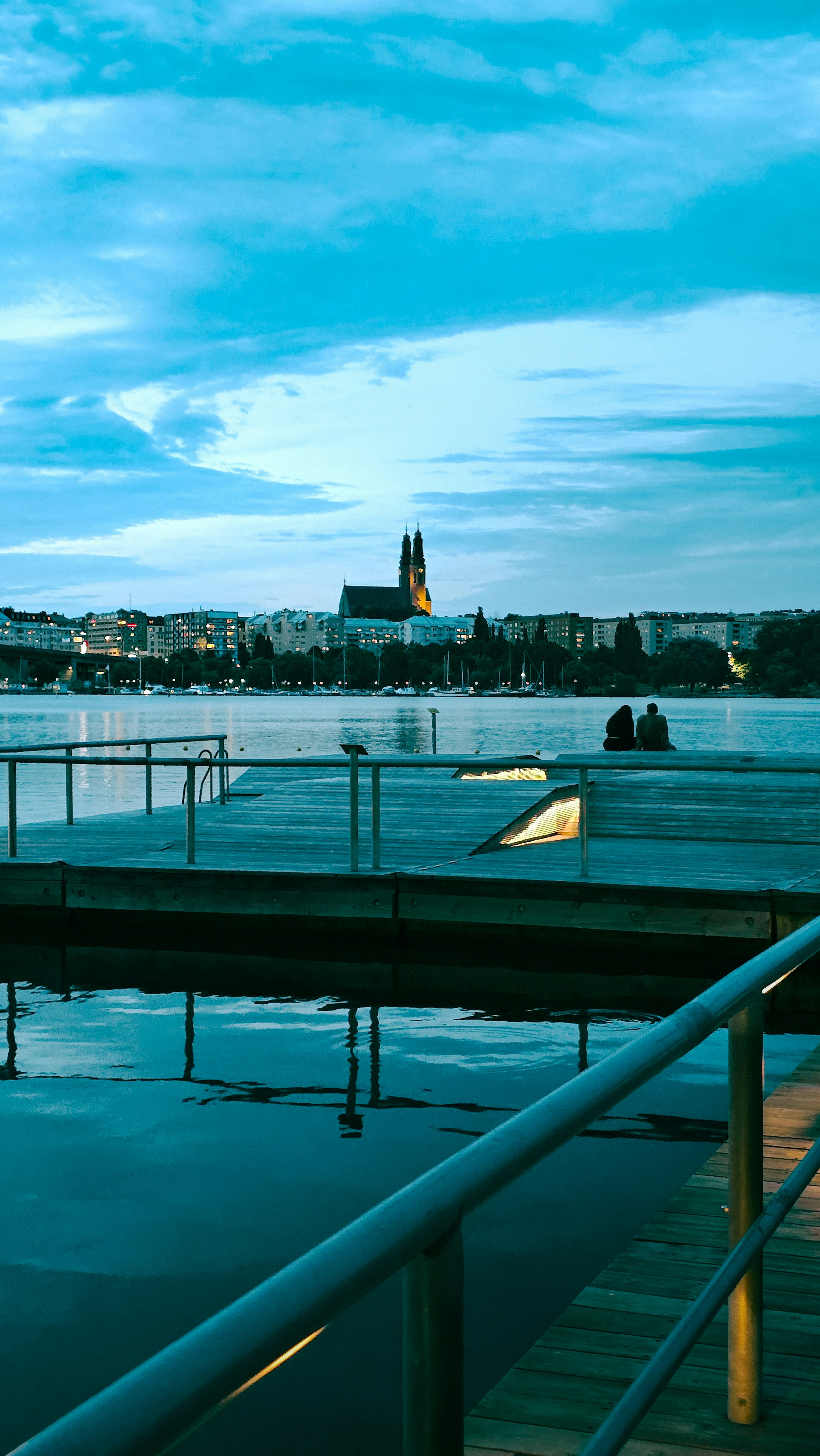 Evening at the Pier: Calm Water Reflects a Crescent Sky