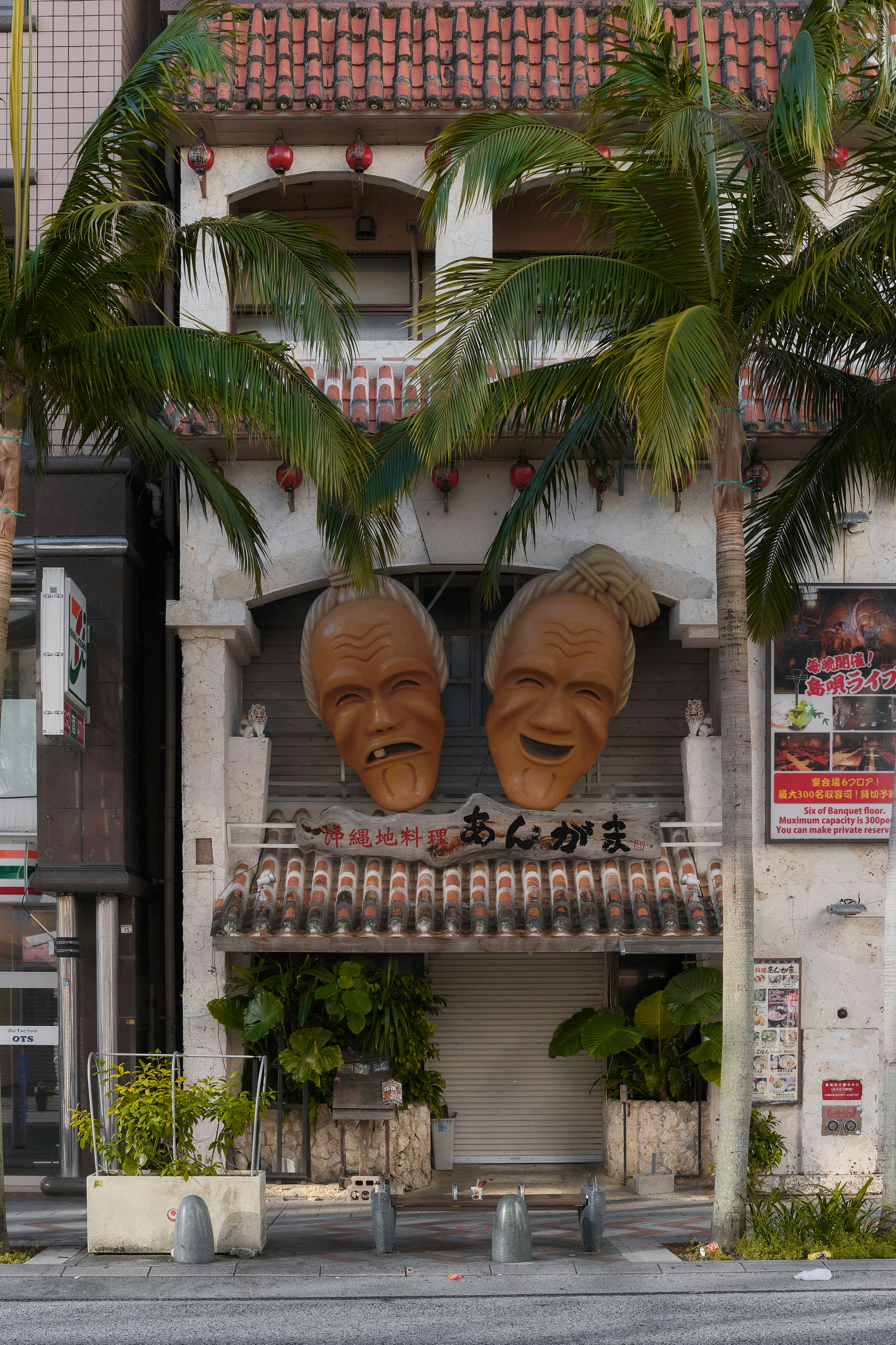 Masked Duo: Theater Masks Over a Sunlit Street Facade