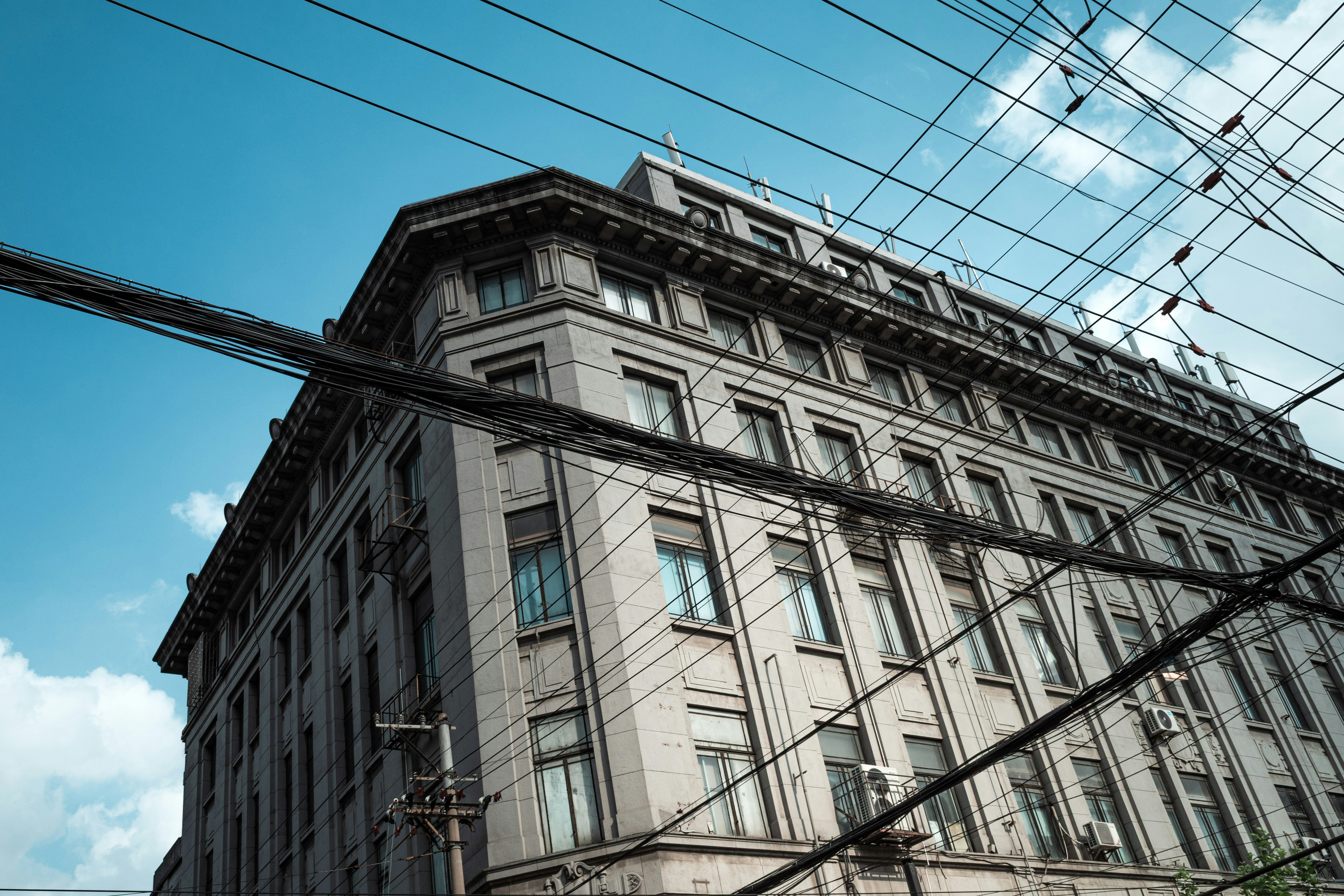 Urban Lattice: Facade of a Historic Building Beneath Tangle of Wires