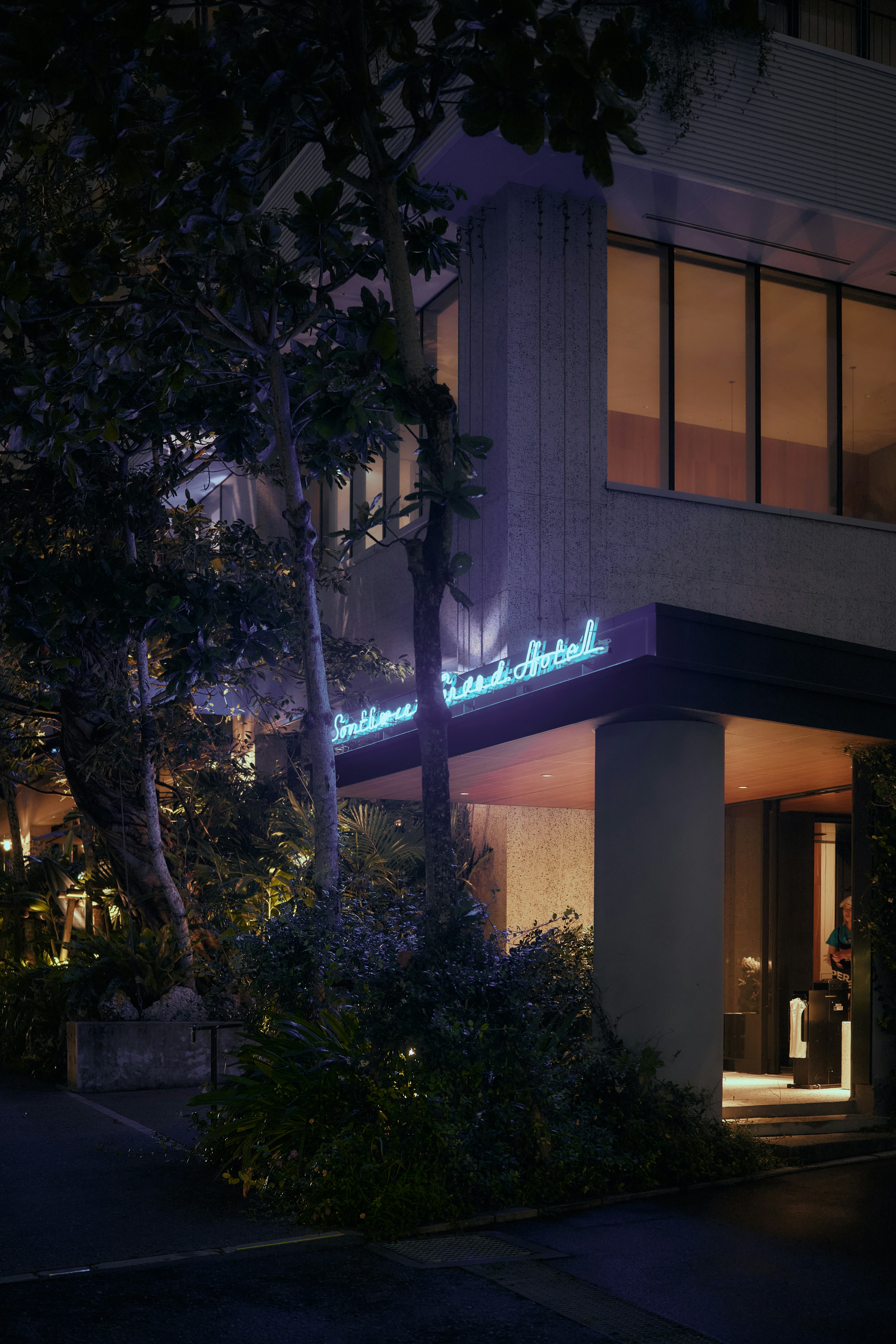 Neon Hospitality at Night: The Blue Sign Illuminates the Entrance