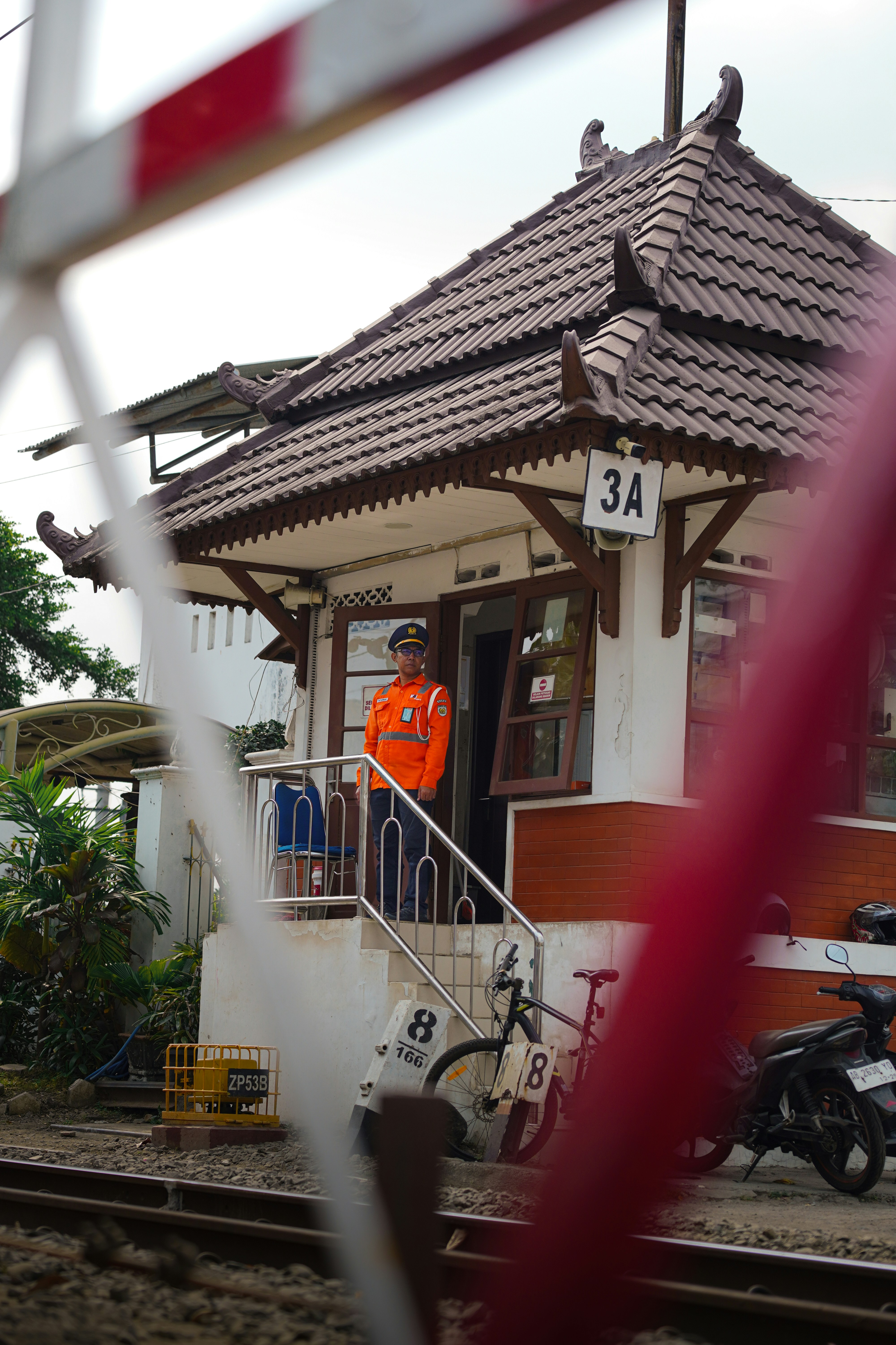 Orange-Uniform Gatekeeper at a Traditional Train Station