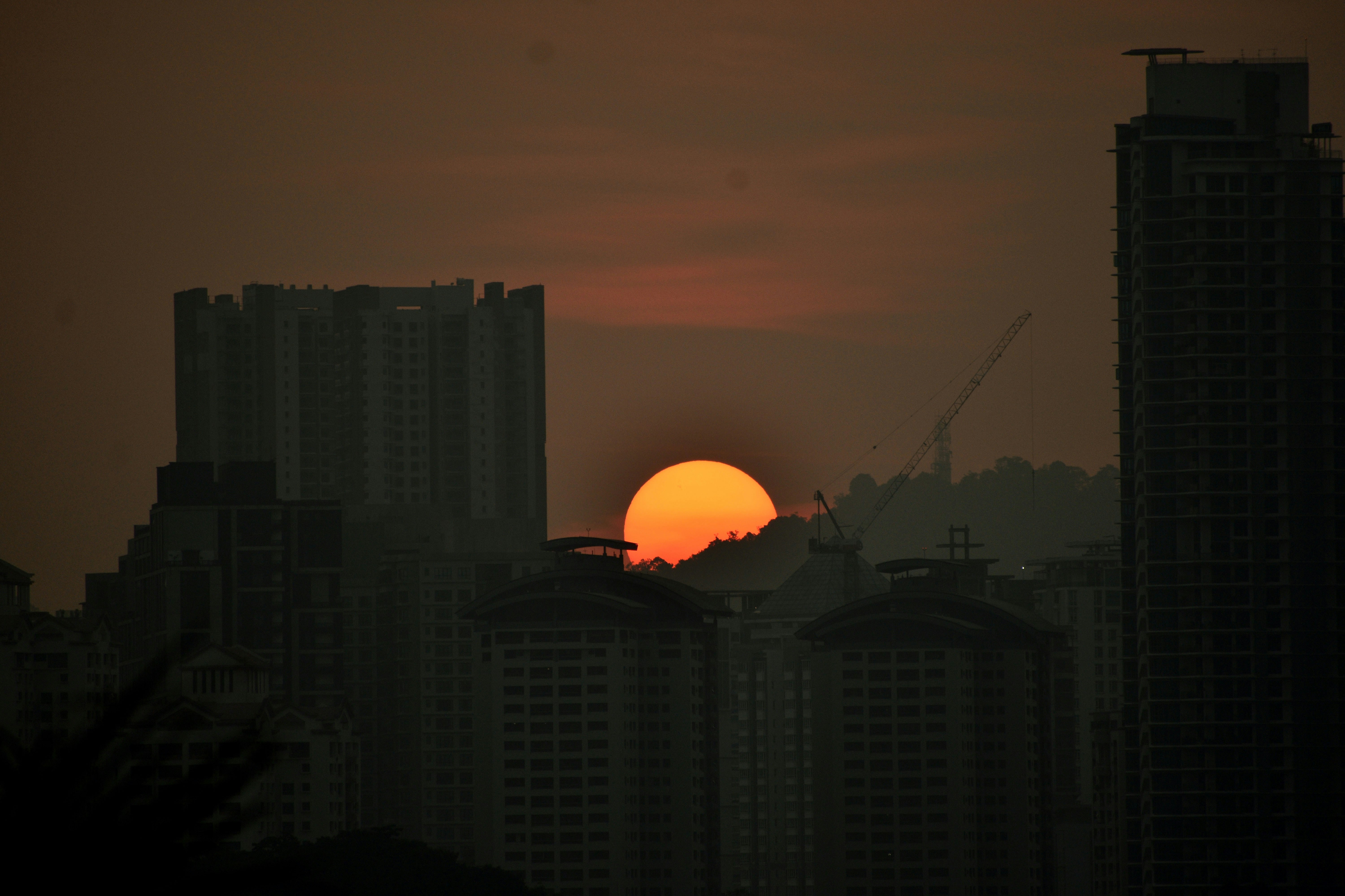 Sunlit Sphere Between Towers: City Silhouette at Dusk