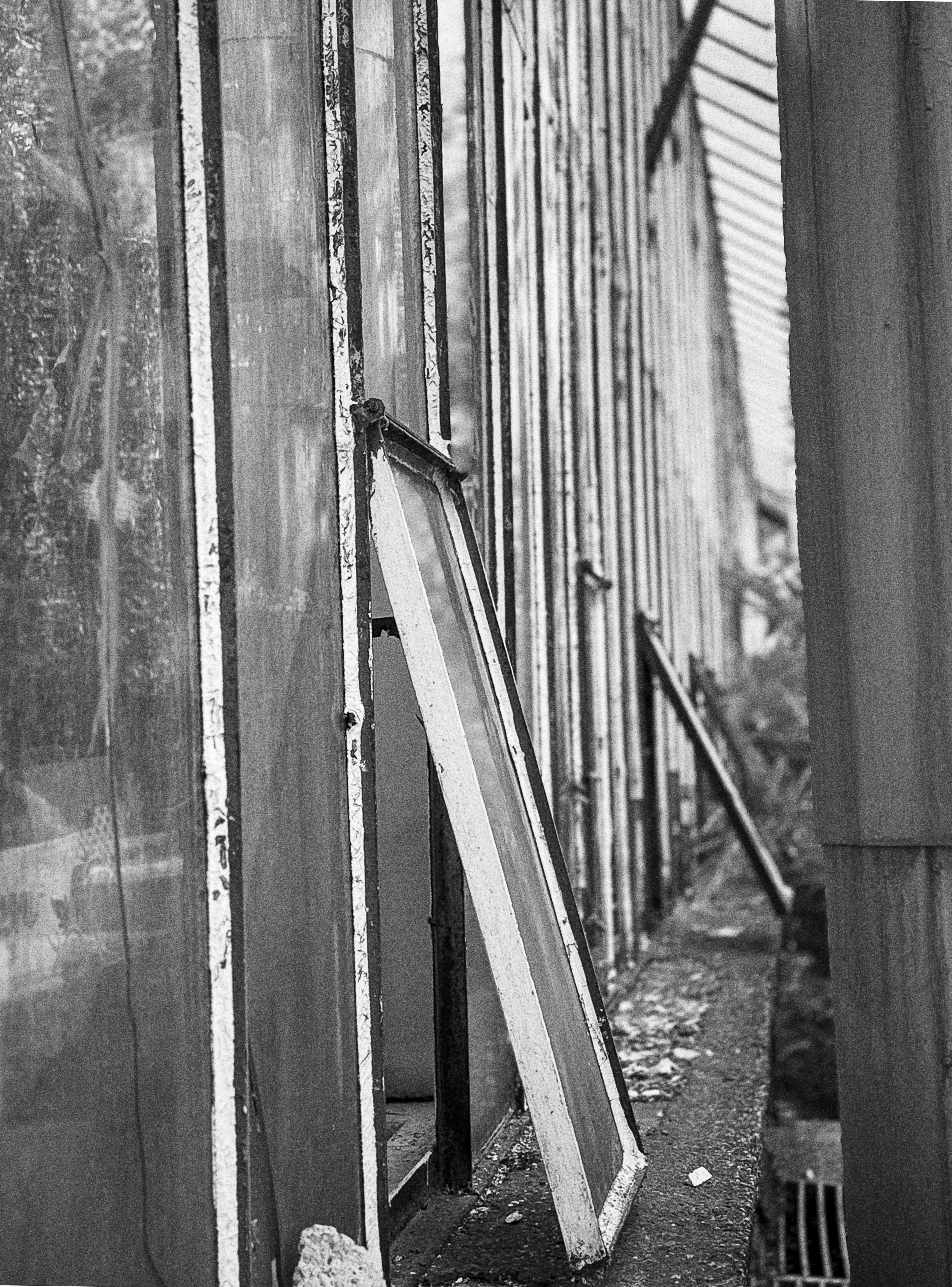 Rusty Doorway Reframed: A Leaning Frame in an Abandoned Corridor