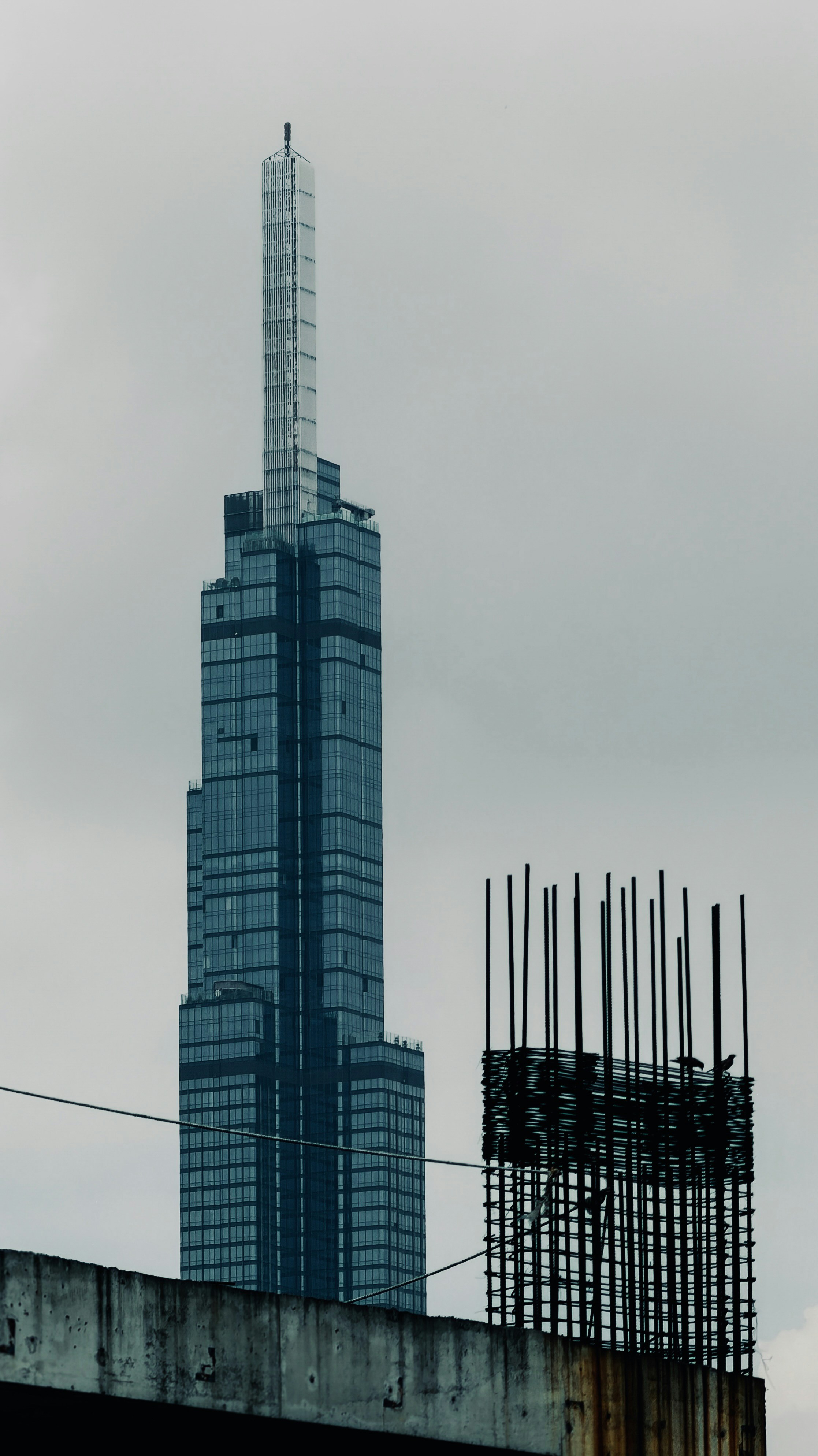 Skyline Ascendant: A Tall Edifice Reaching Toward a Cloudy Sky