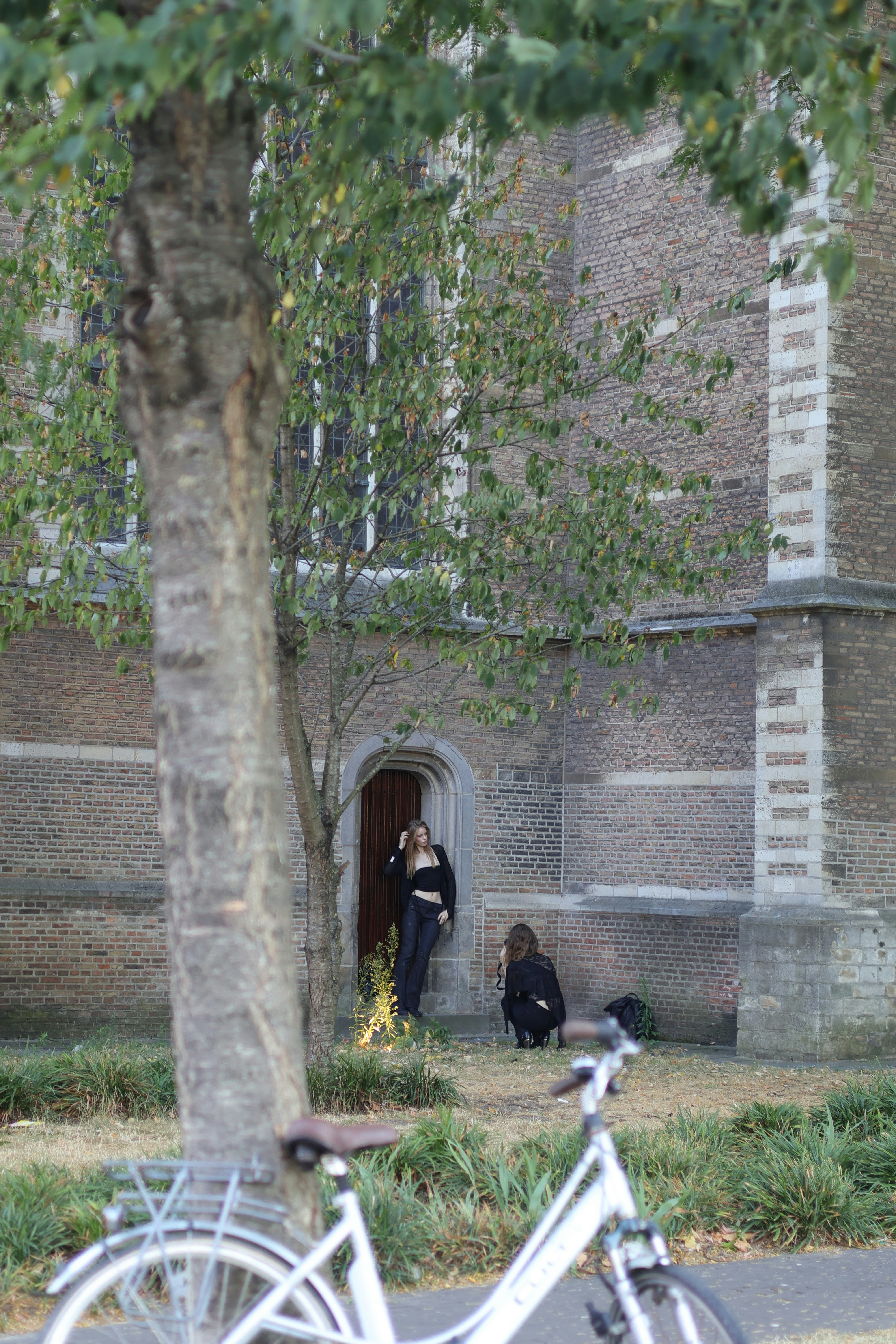 Courtyard Figure: A Moment by the Old Brick Facade