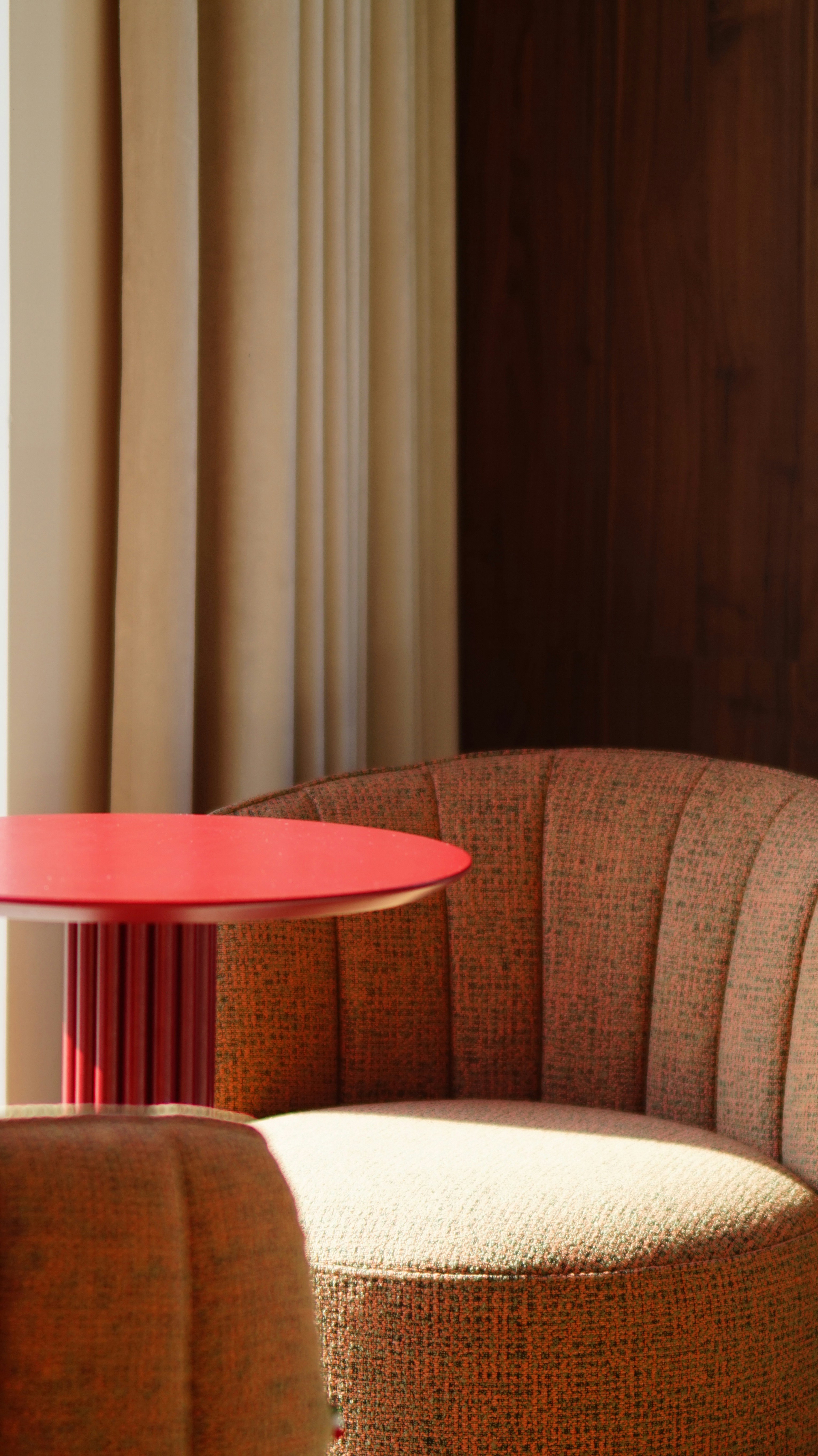 Sunlit Corner: A Cozy Club Chair by a Red Table