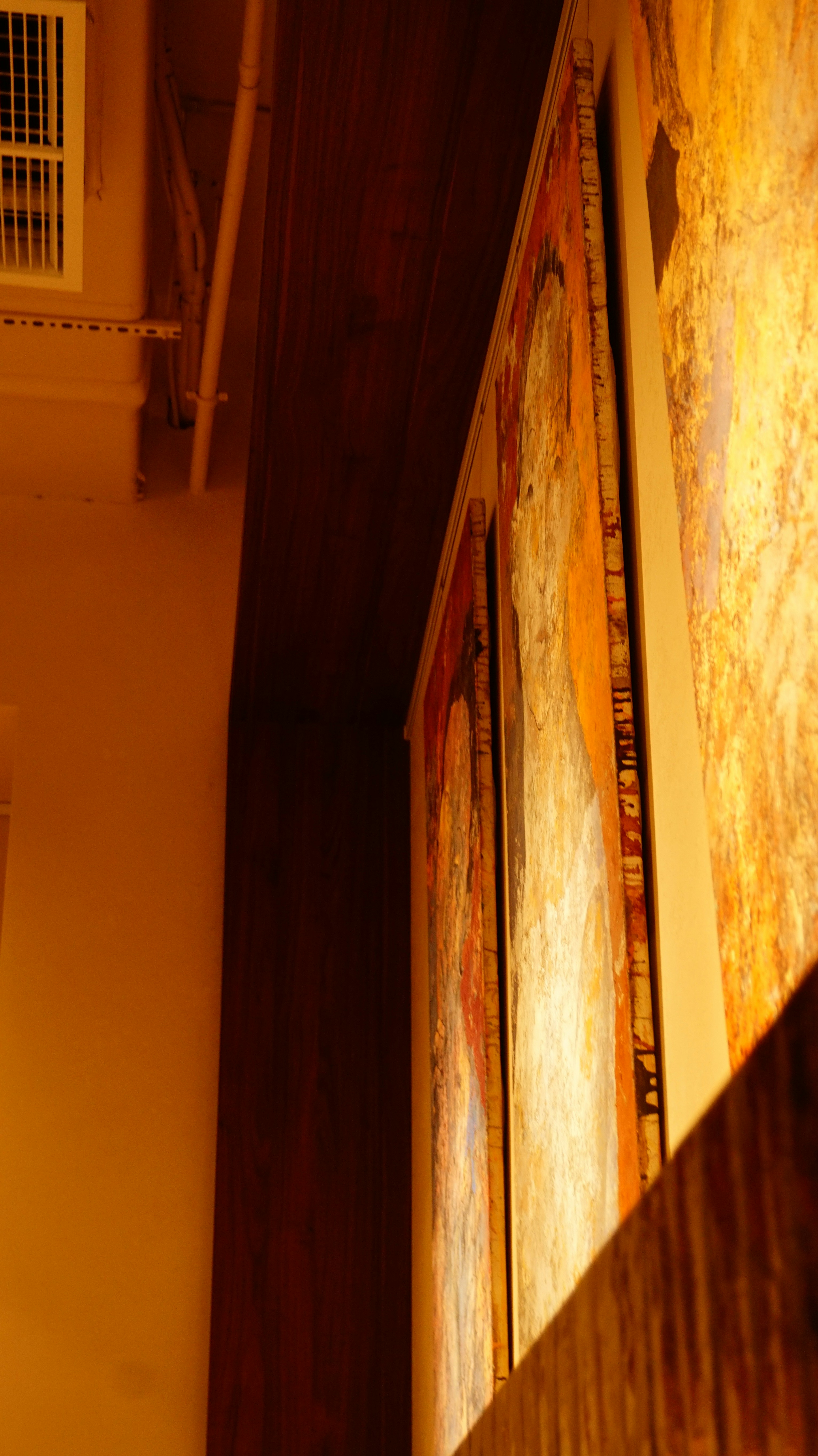 Warm-tinted Gallery: Framed Textures in a Narrow Corridor