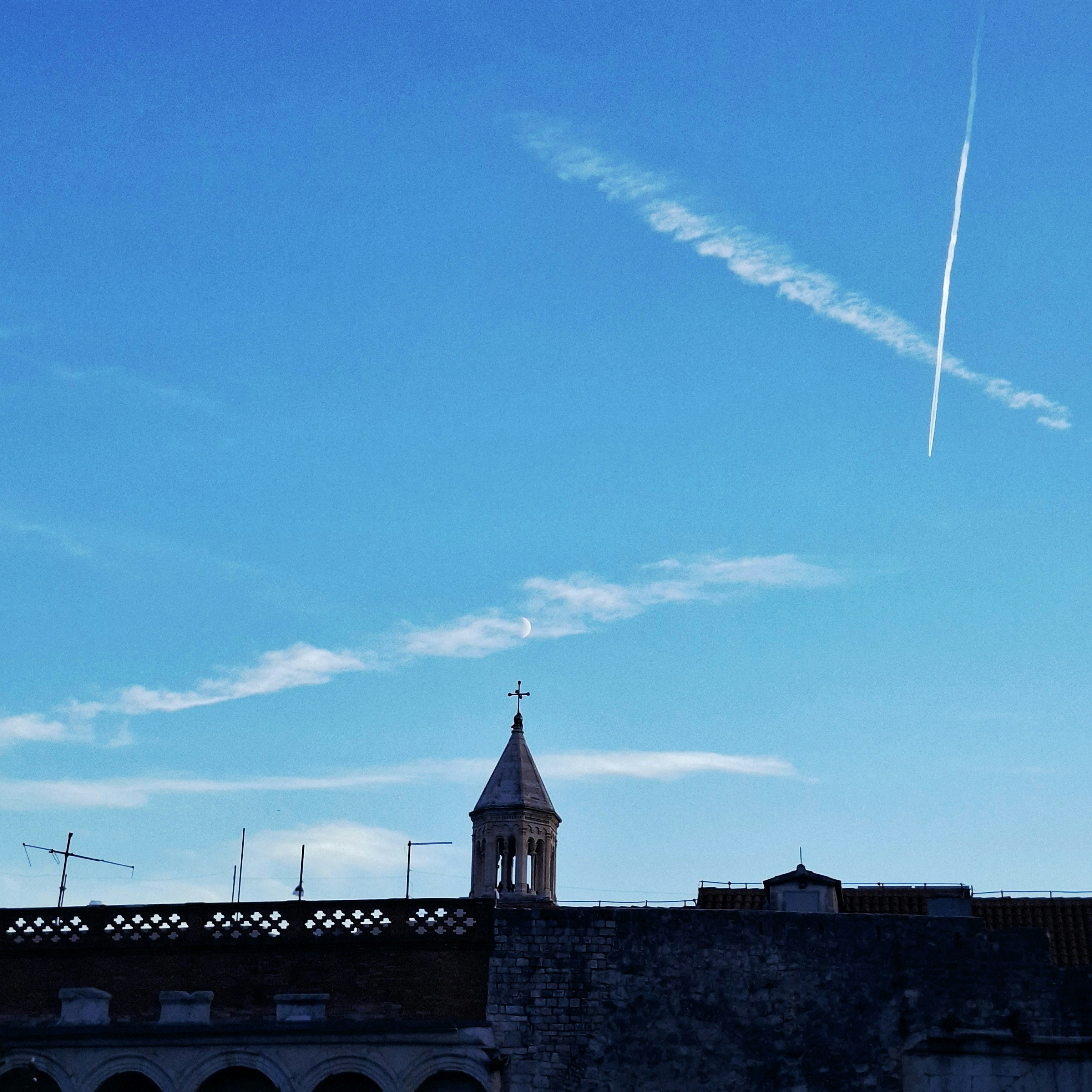 Rooftop Crosses and Skyward Contrail