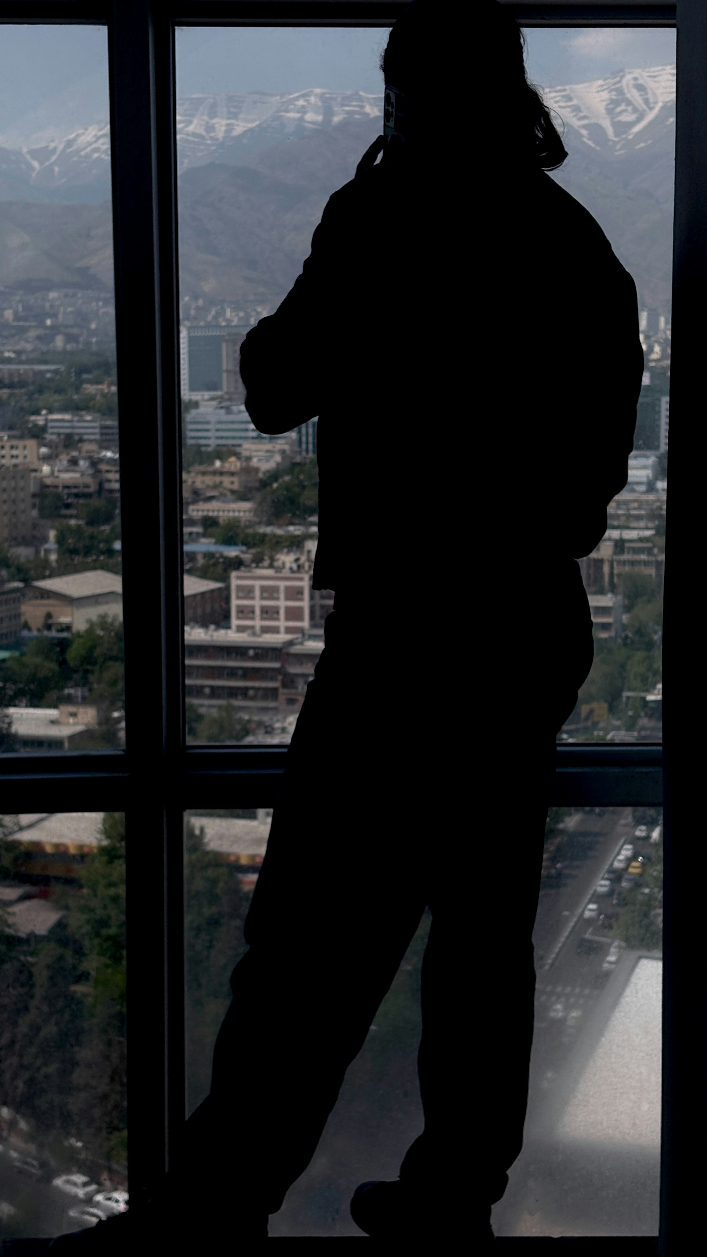 Silhouette at the Window: Urban Horizon Behind a Gaze