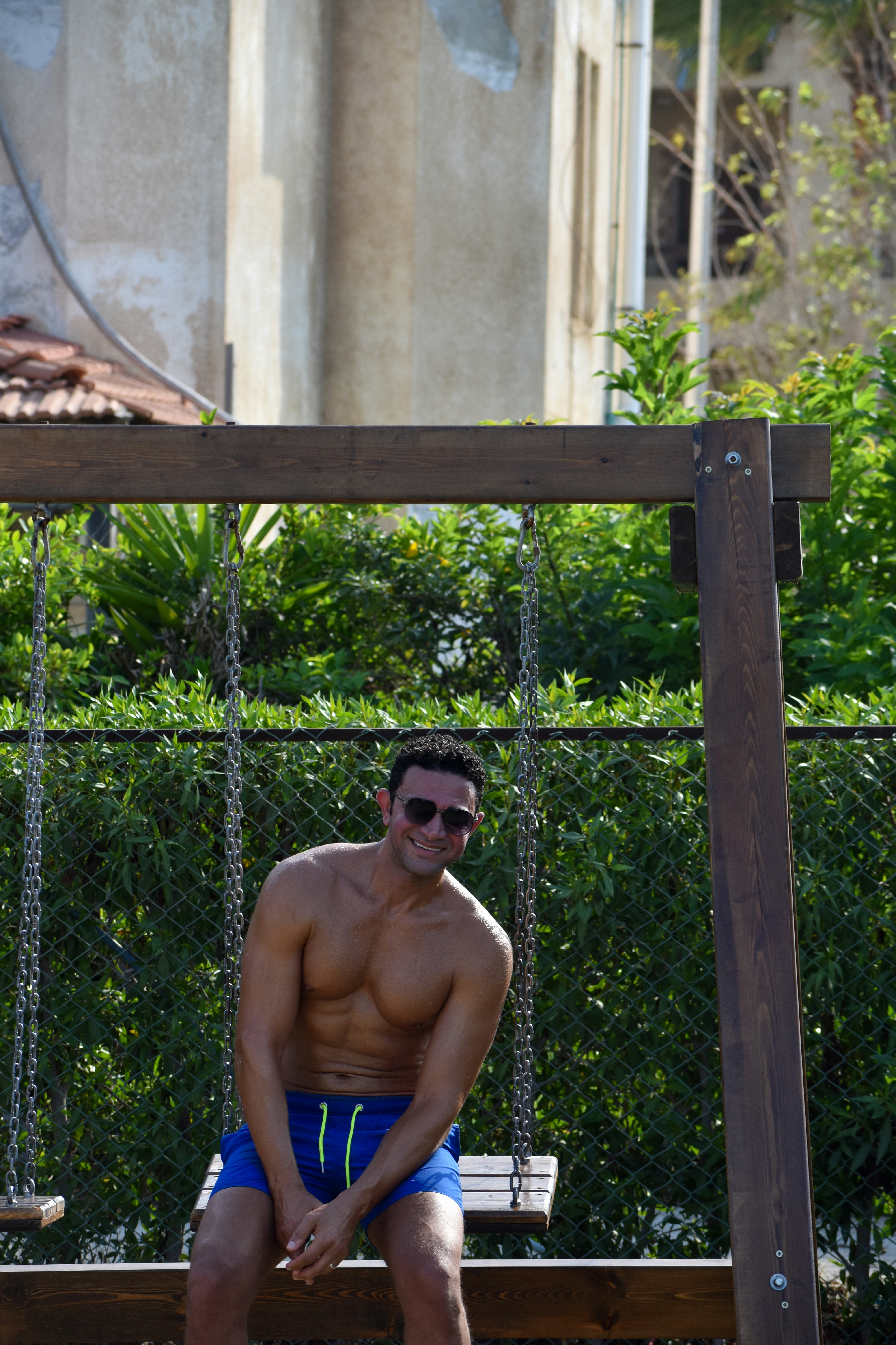 Sunlit Swing: A Casual Moment by the Garden Fence