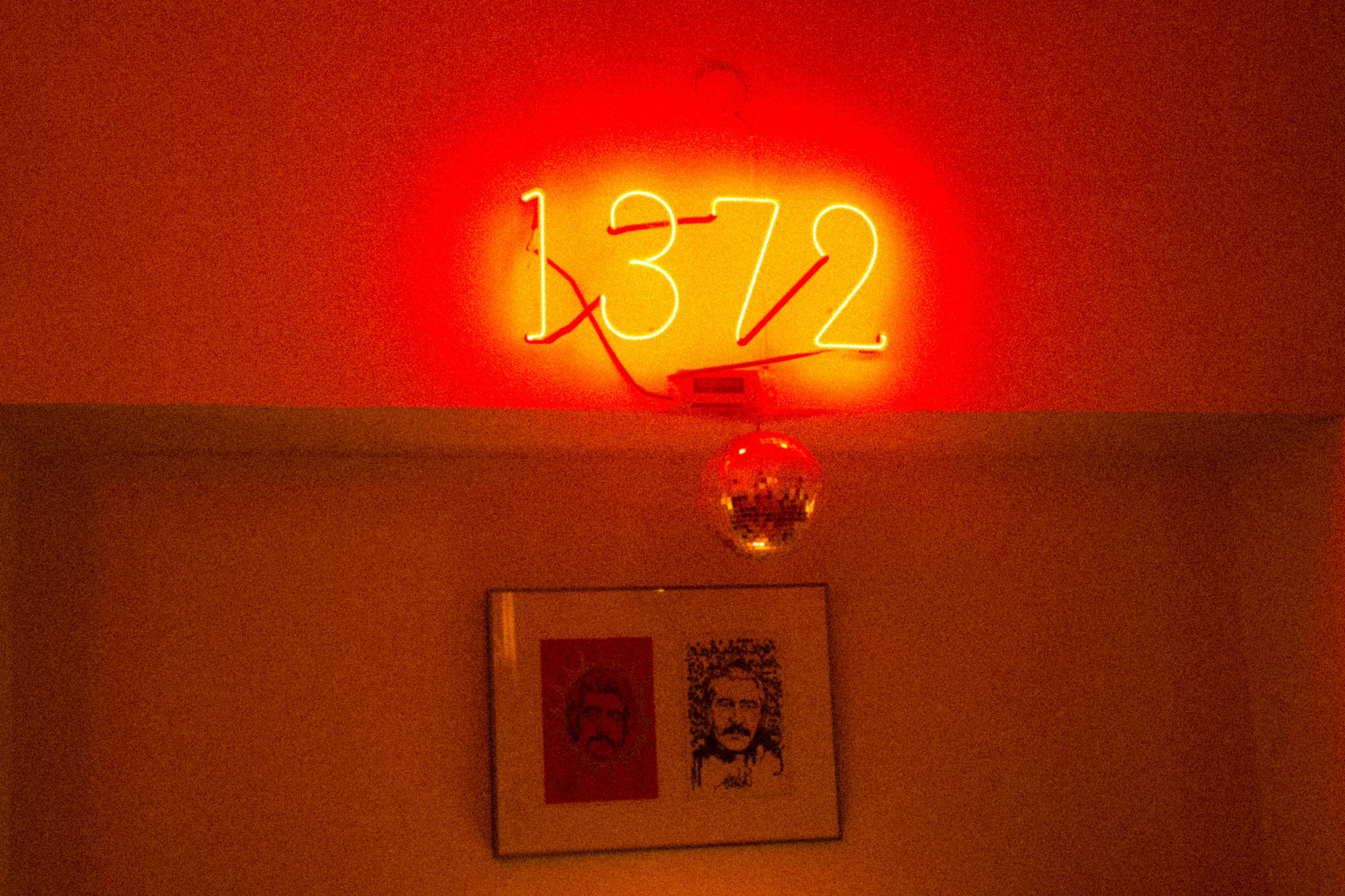 Neon Sign Over a Framed Portrait: A Quiet Hallway Moment