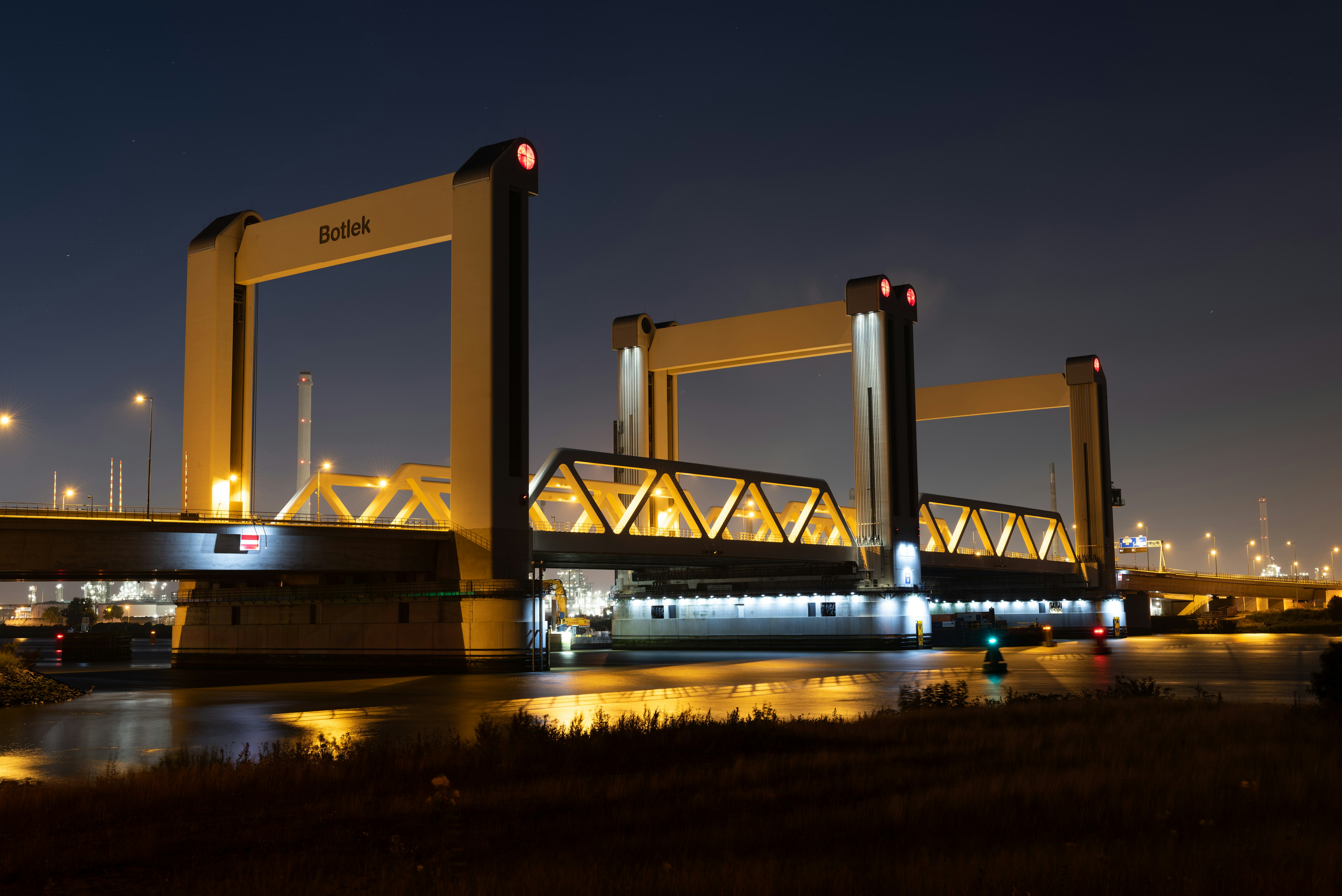 Golden Gate: Nighttime Hydraulic Gate Illuminates the Thames of Waterfront Machinery