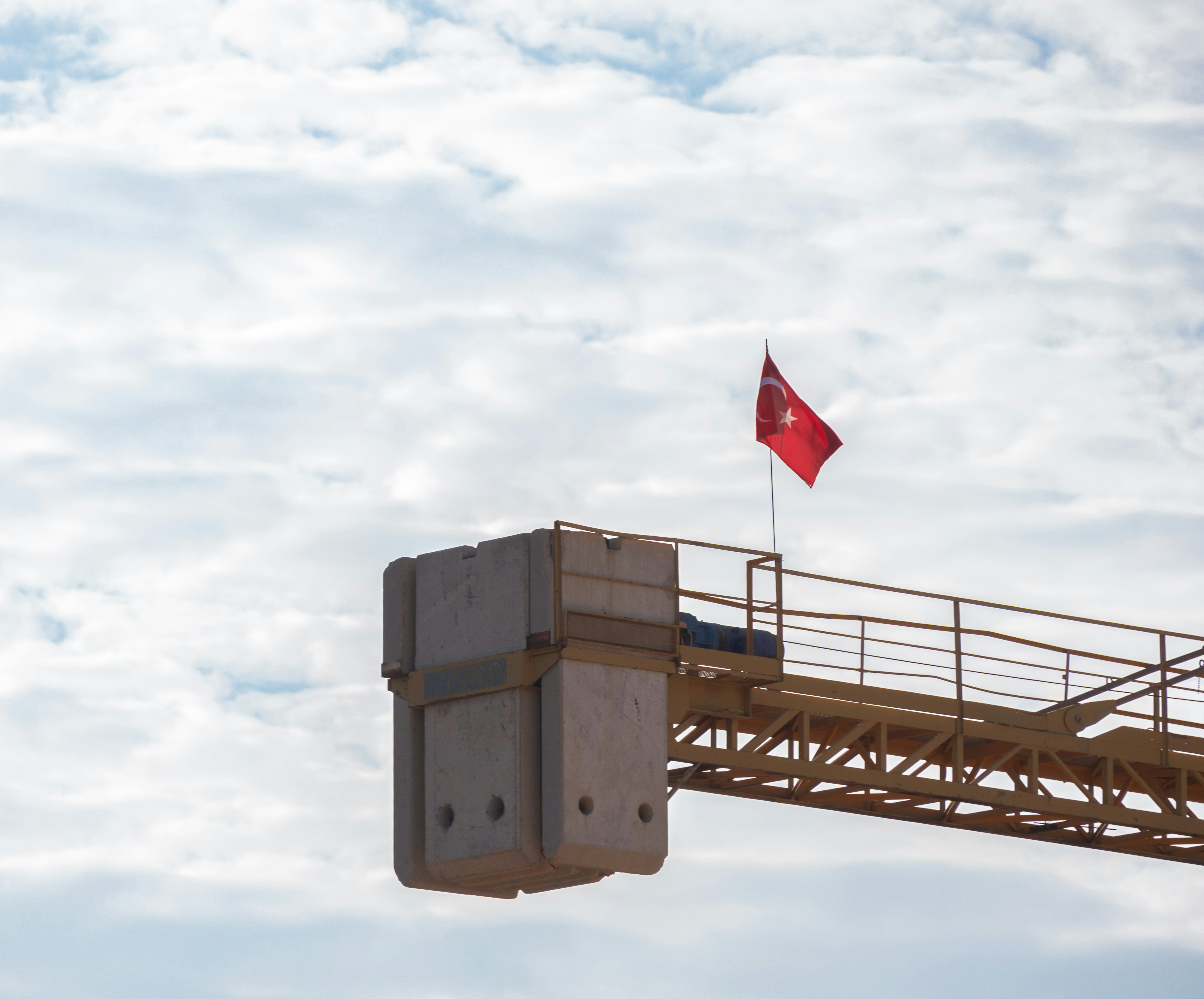 Flag on a Crane Arm Against a Sky River