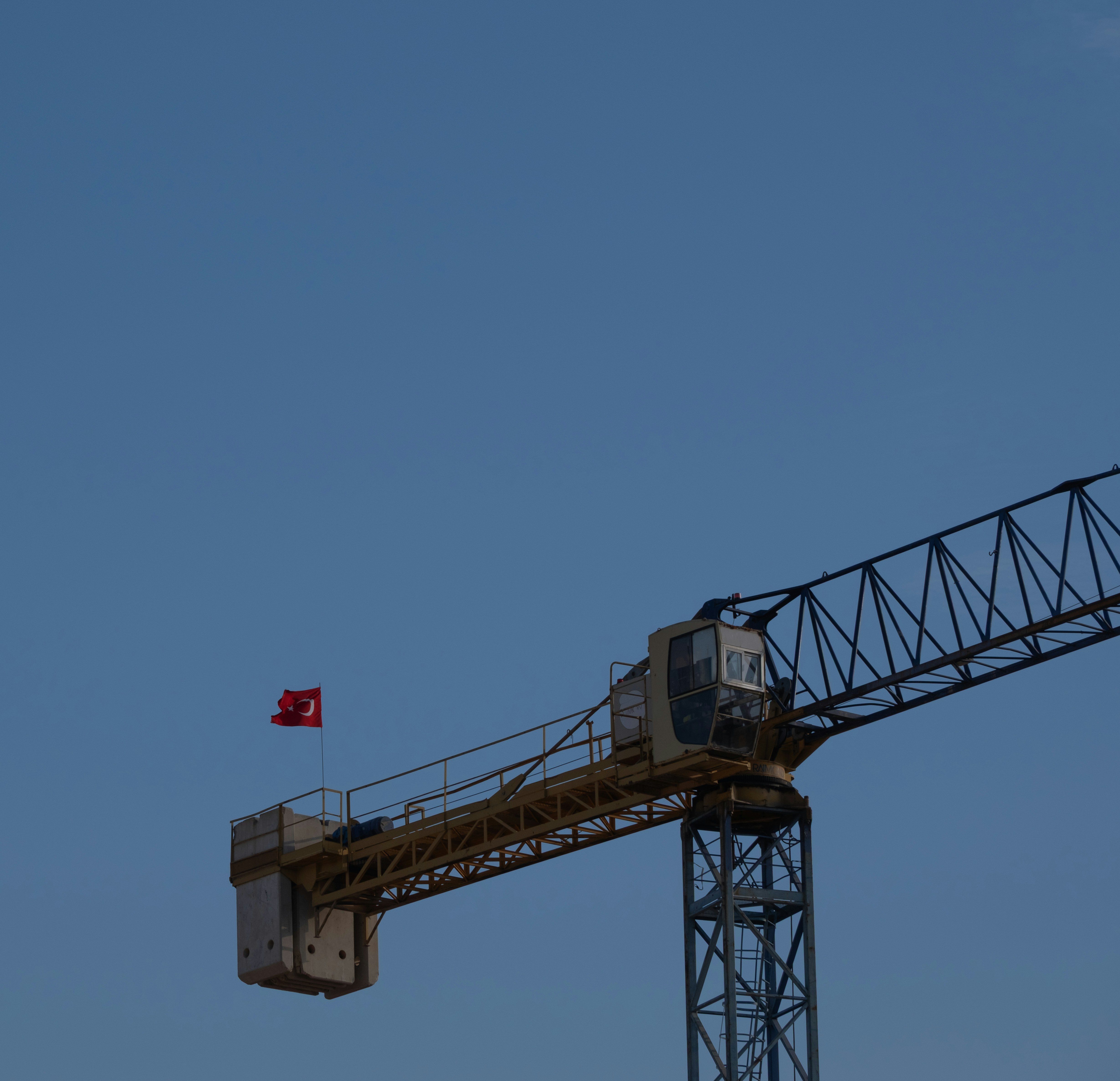 Turkish Flag atop a Crane Pendant in a Clear Sky