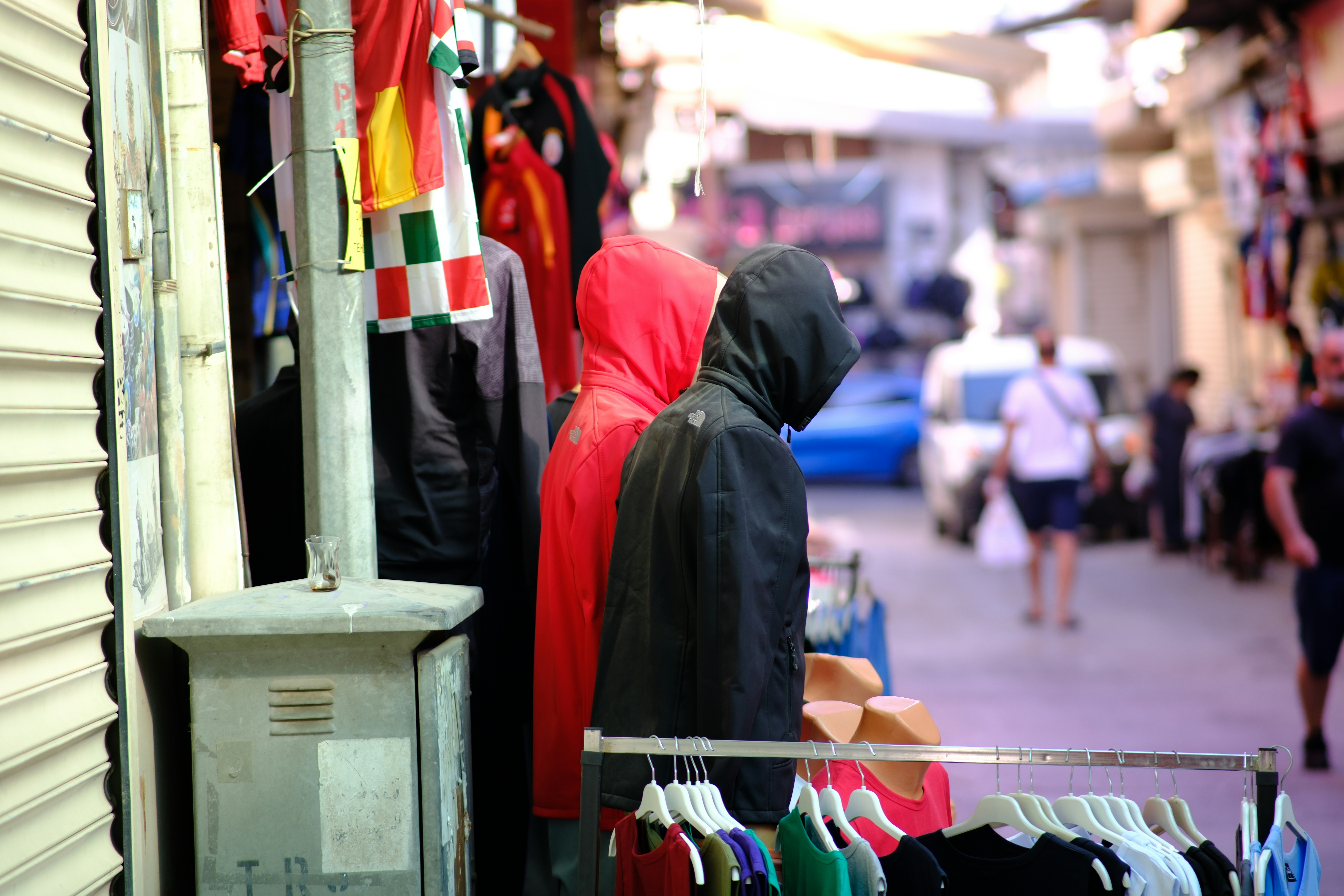 Hidden Hoods of the Market: Red and Black Cloaks in a Quiet Alley