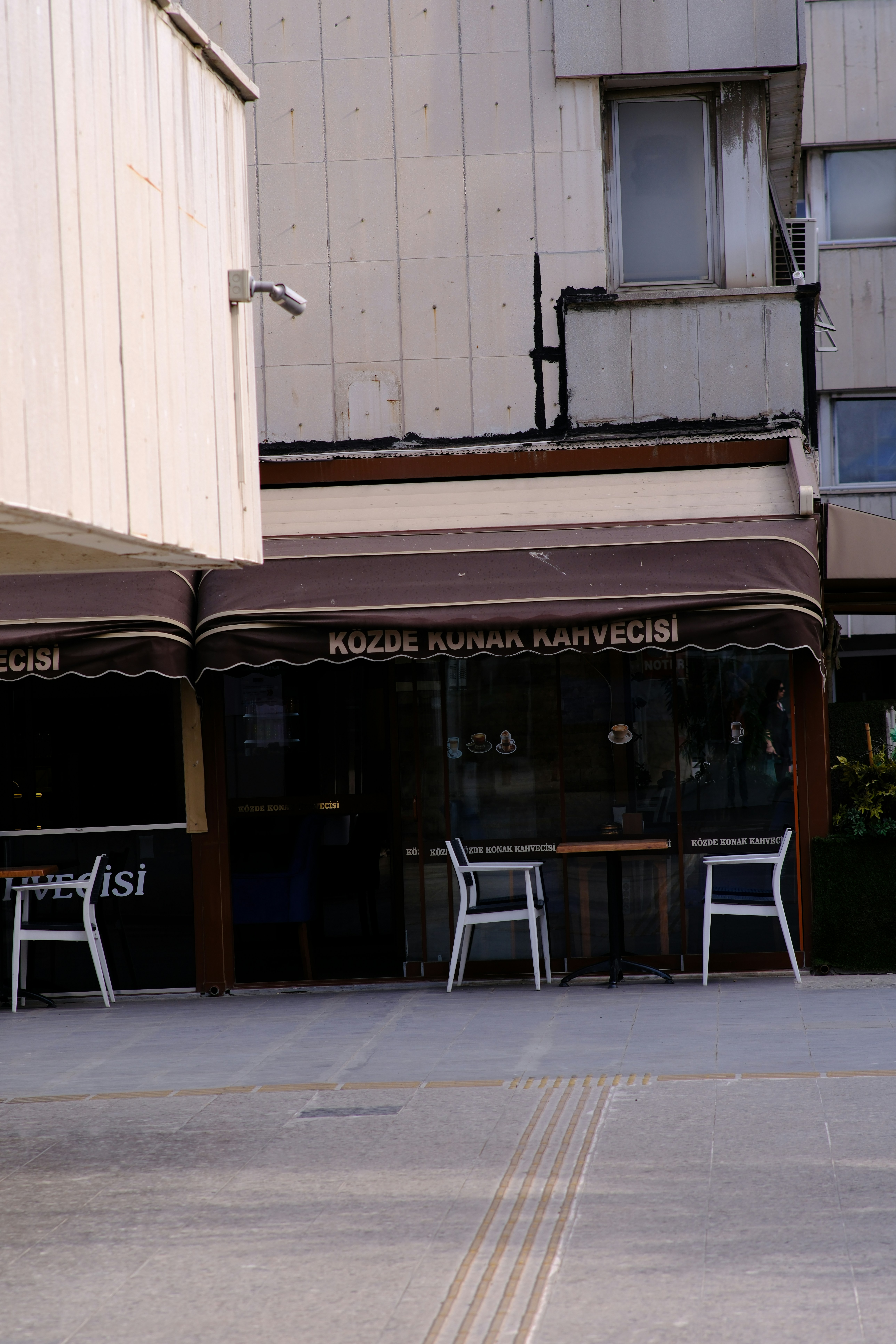 Cafe Facade at Dusk: Quiet Outdoor Seating Under a Shaded Canopy