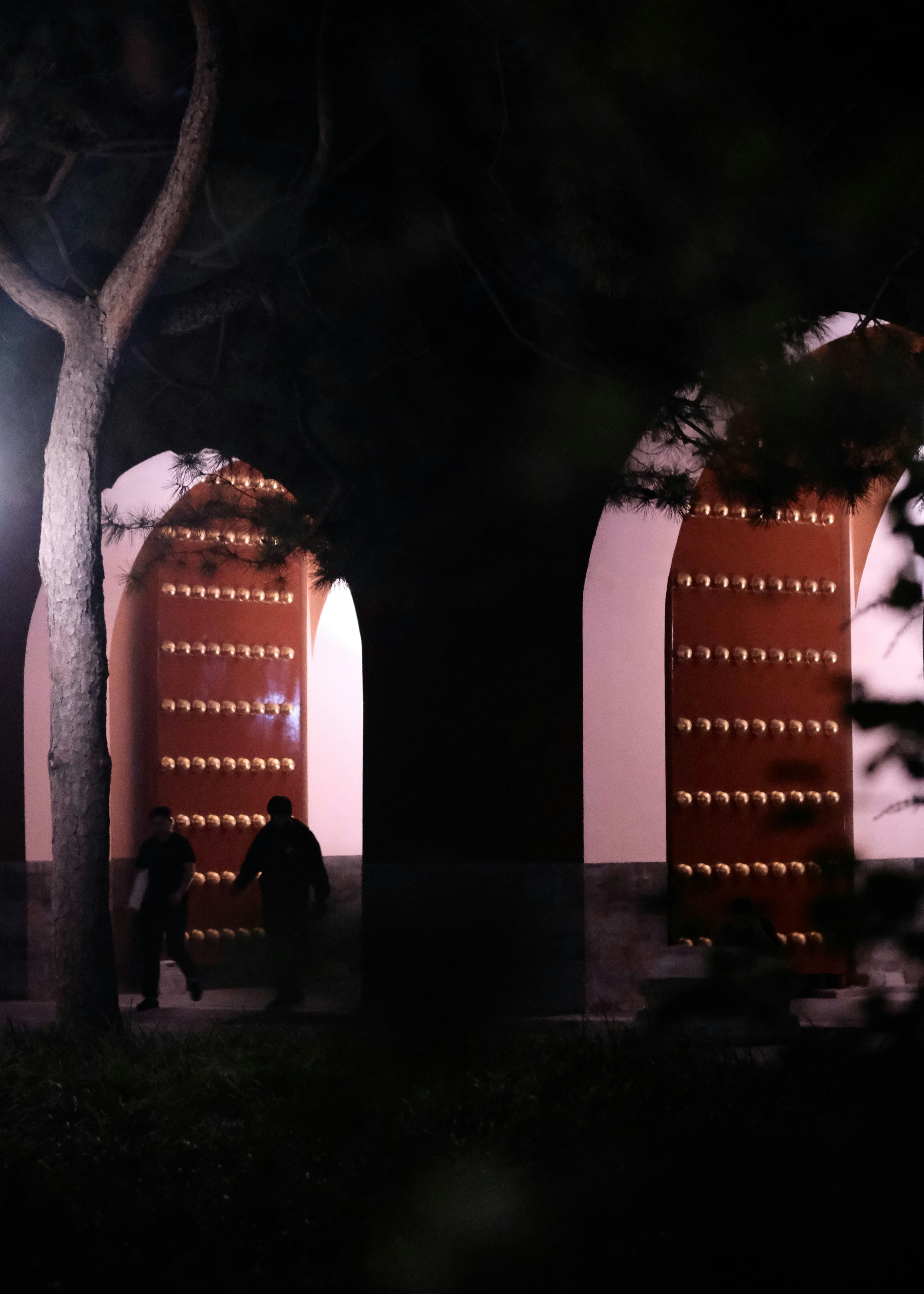 Archway Lanterns at Night: Silent Figures in the Gate
