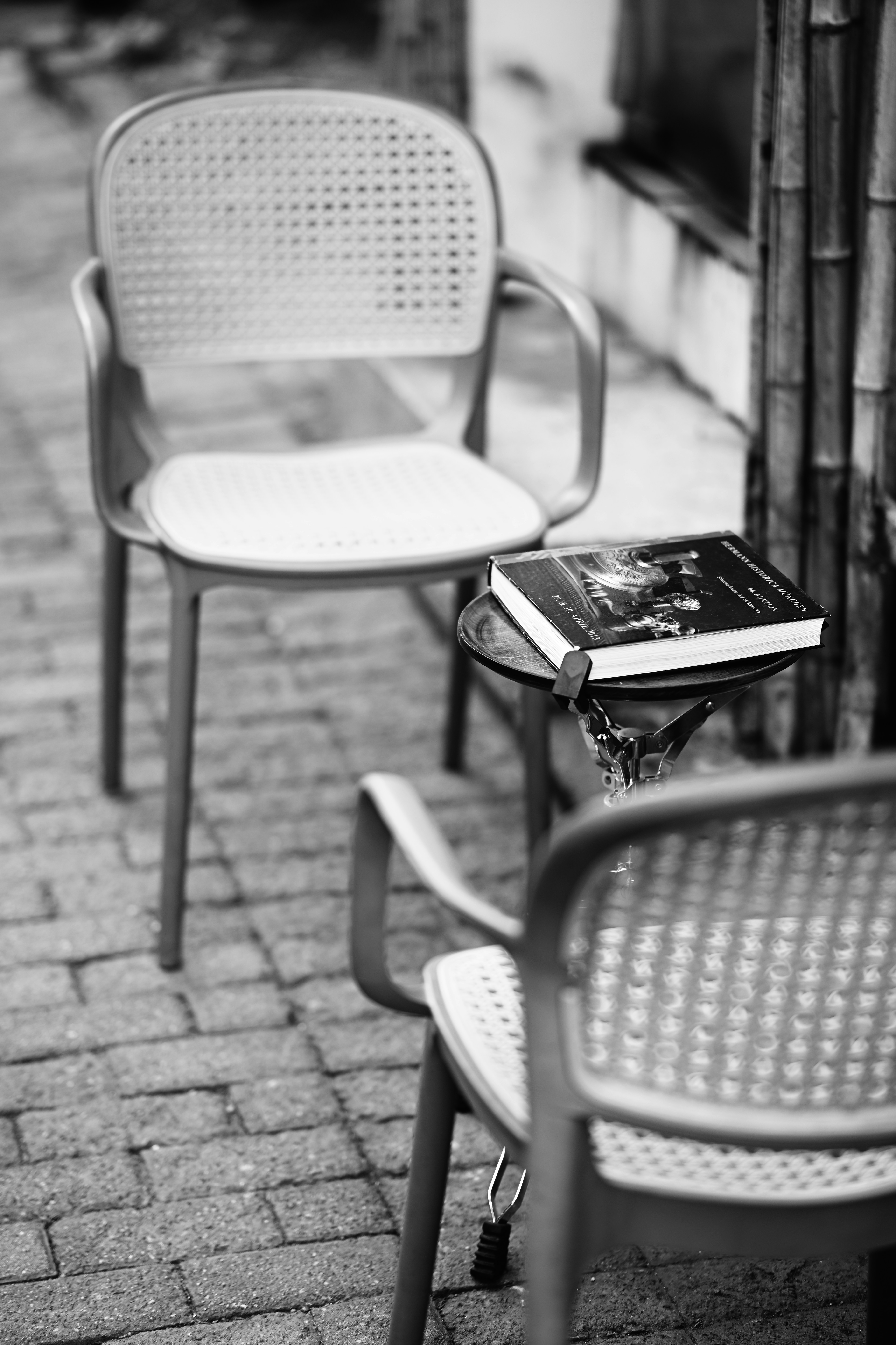 Quiet Street Café: A Book Resting on a Table Between Chairs