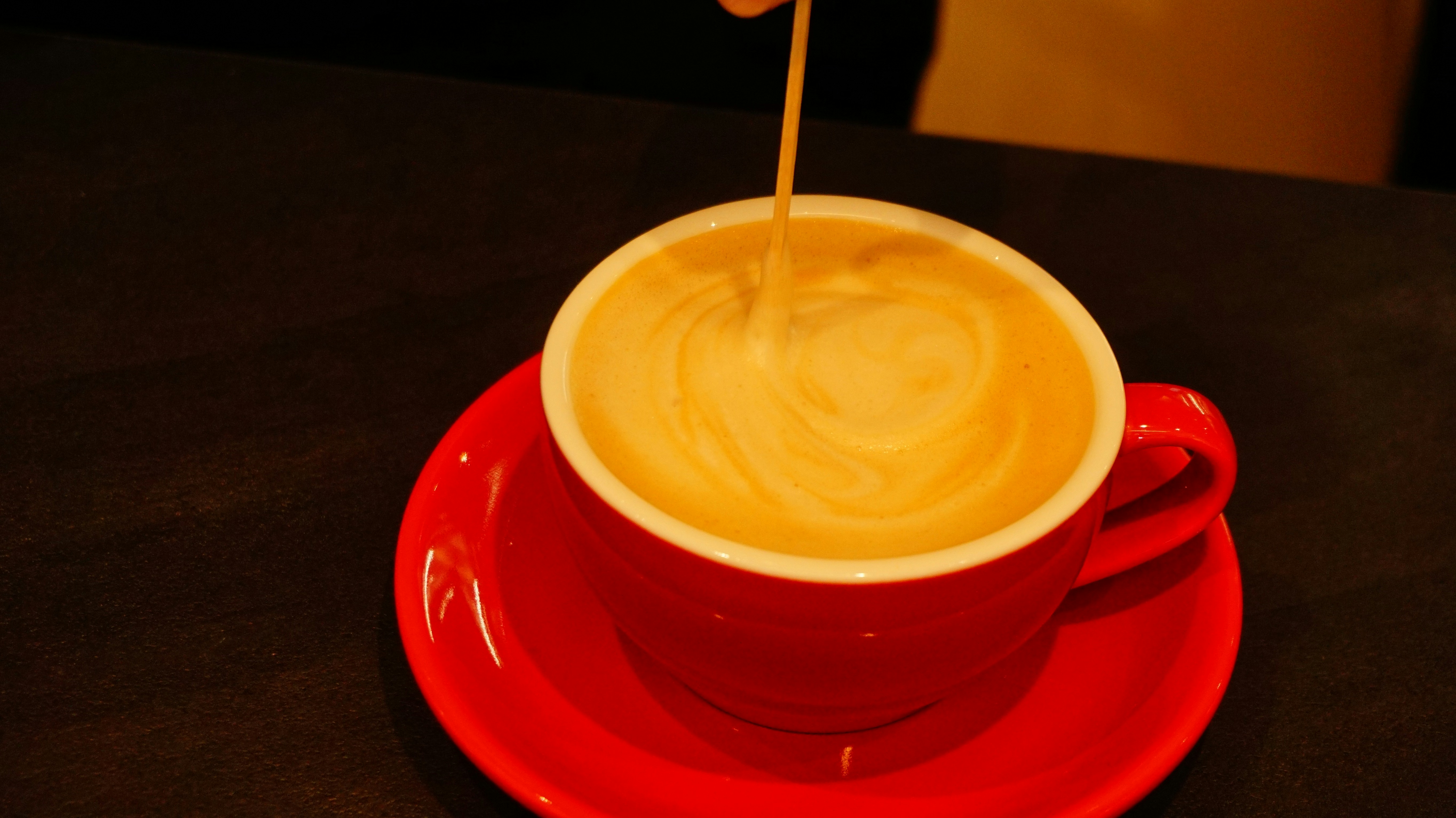 Crimson Cup: A Latte Constellation on a Dark Surface